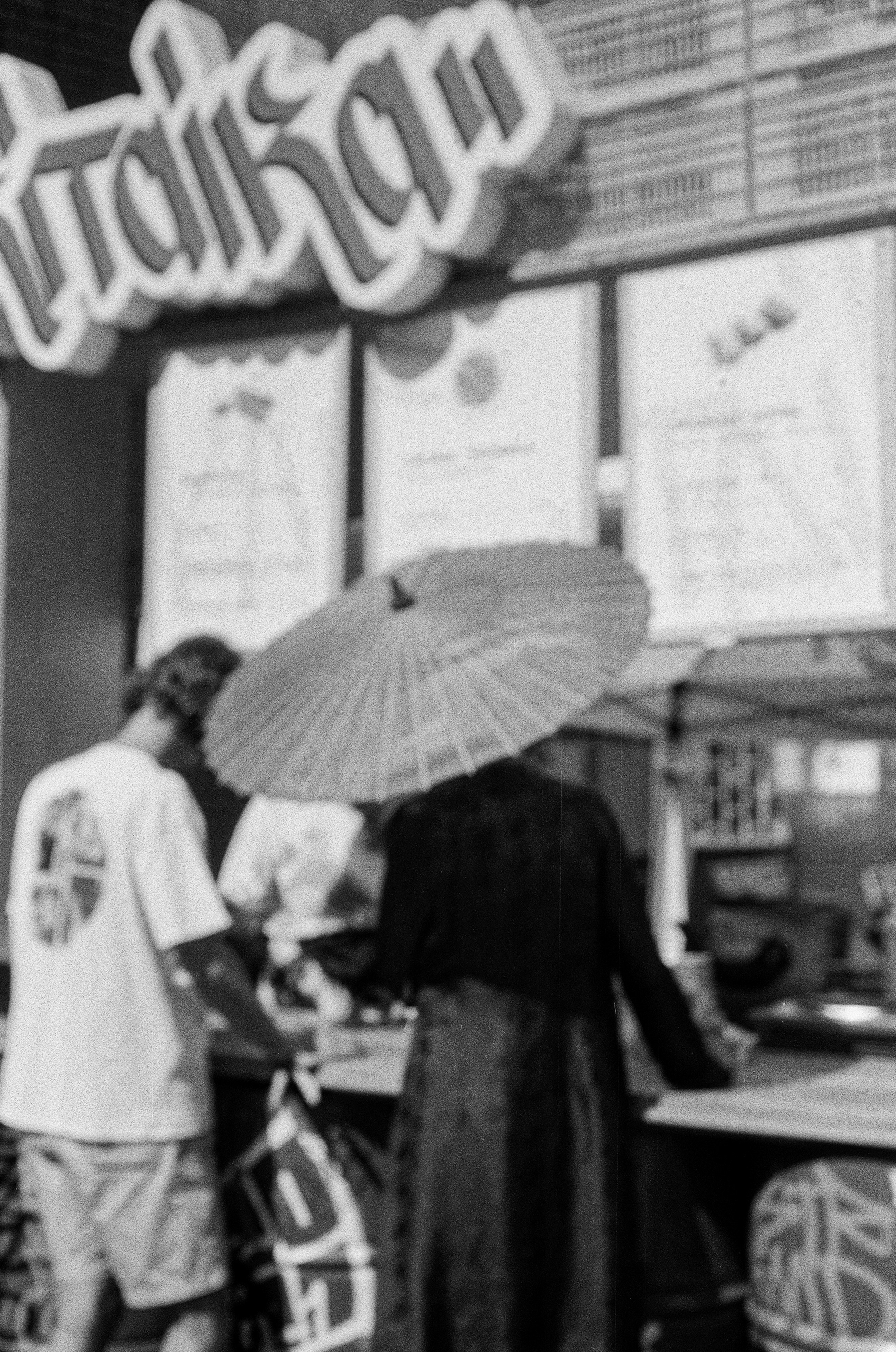 grayscale photo of man and woman holding umbrella