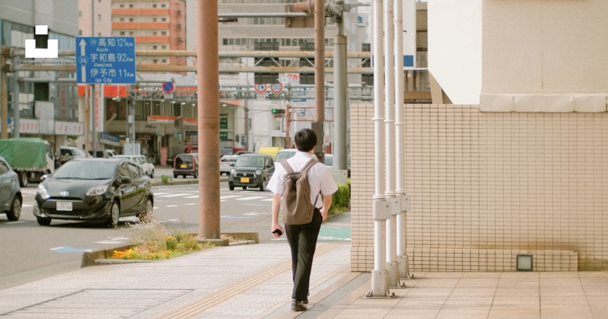 하얀 드레스 셔츠와 검은 바지를 입은 남자가 낮 동안 보도를 걷고 있다 사진 Unsplash의 무료 자동차 이미지