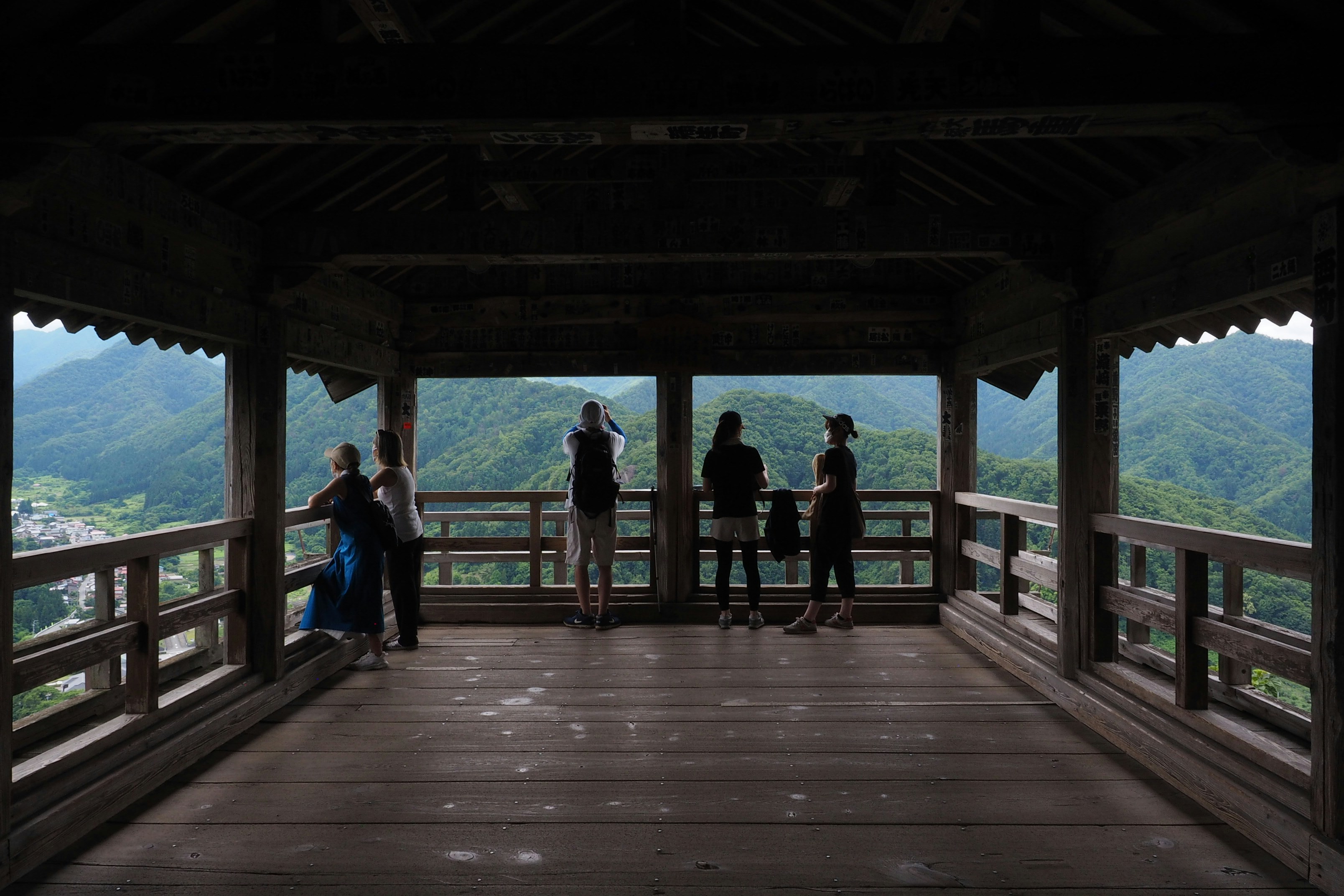 Quiet Overlook: Visitors at a Mountain Vista from a Timbered Deck