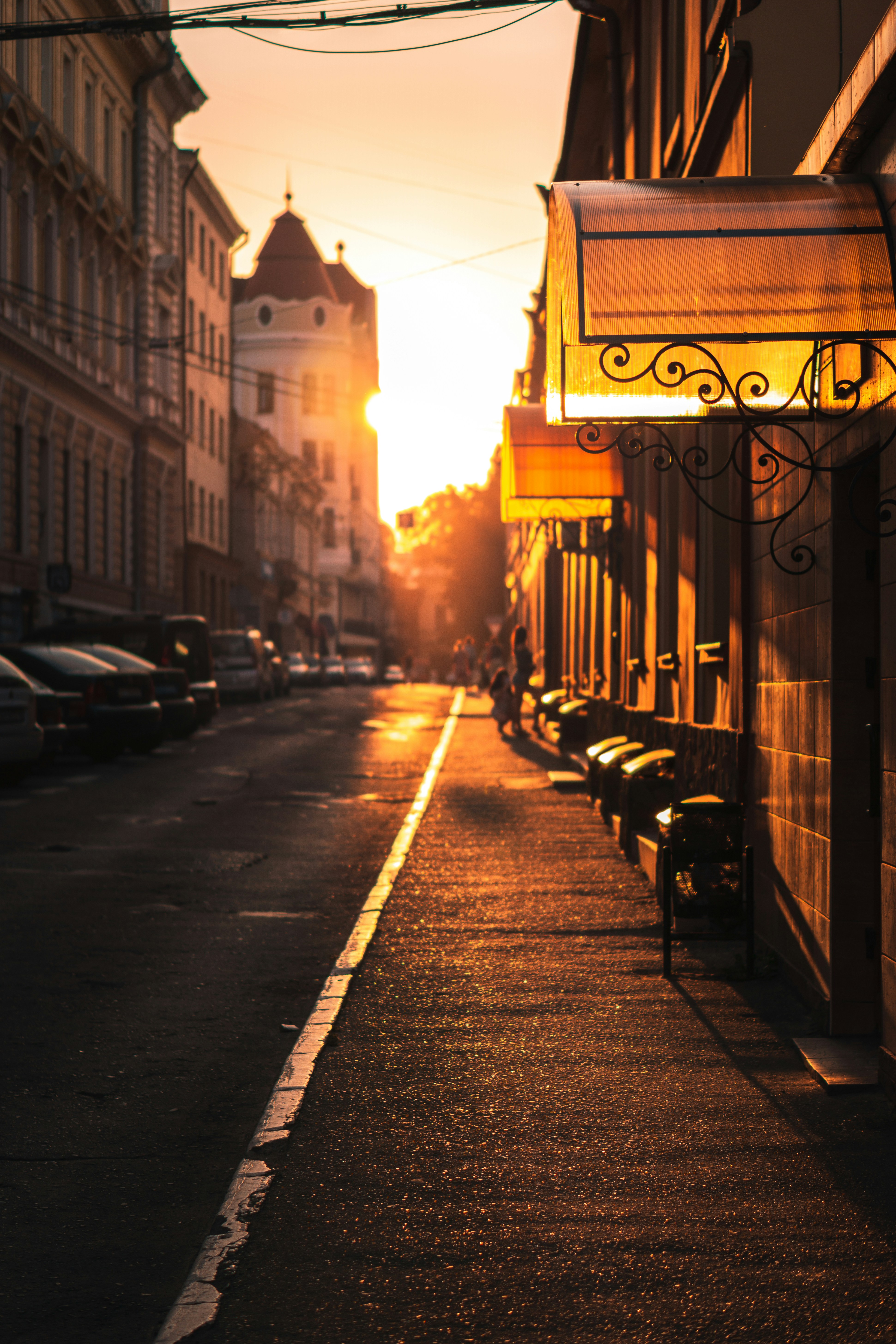 Golden Hour Corridor: Sunlit Facades and an Ornate Awning