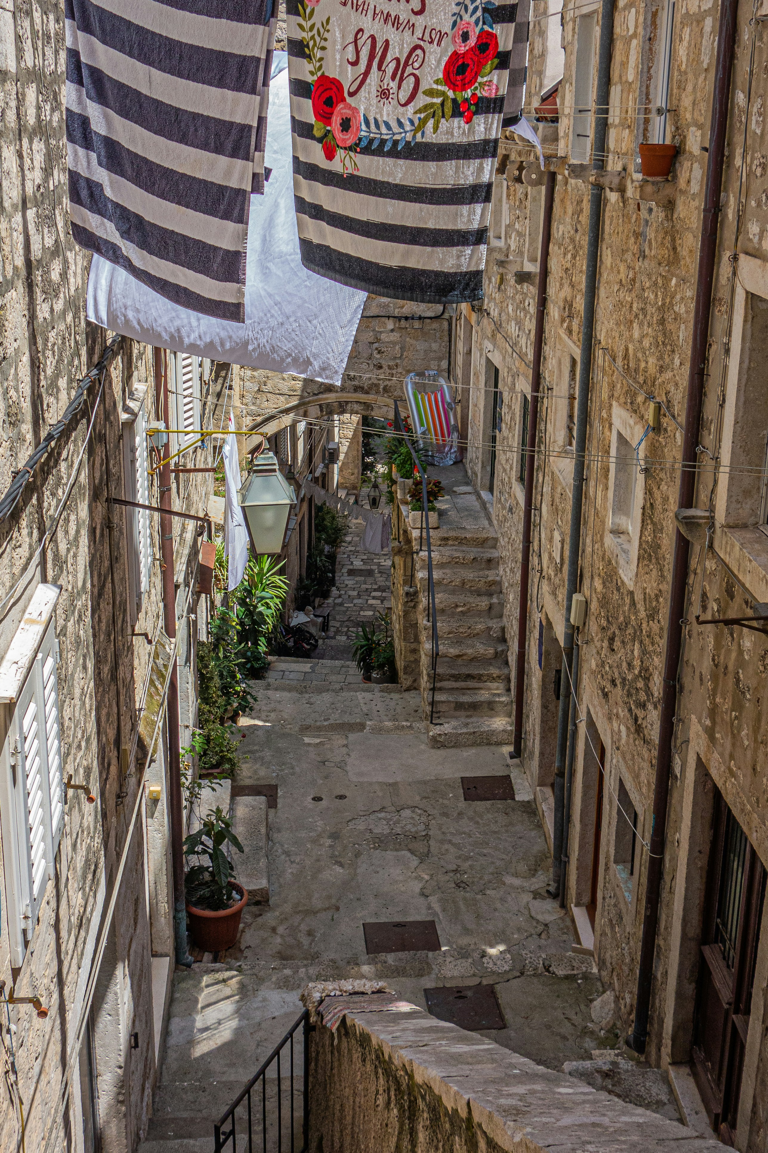 Narrow Mediterranean Alleyway Draped in Sunlit Laundry