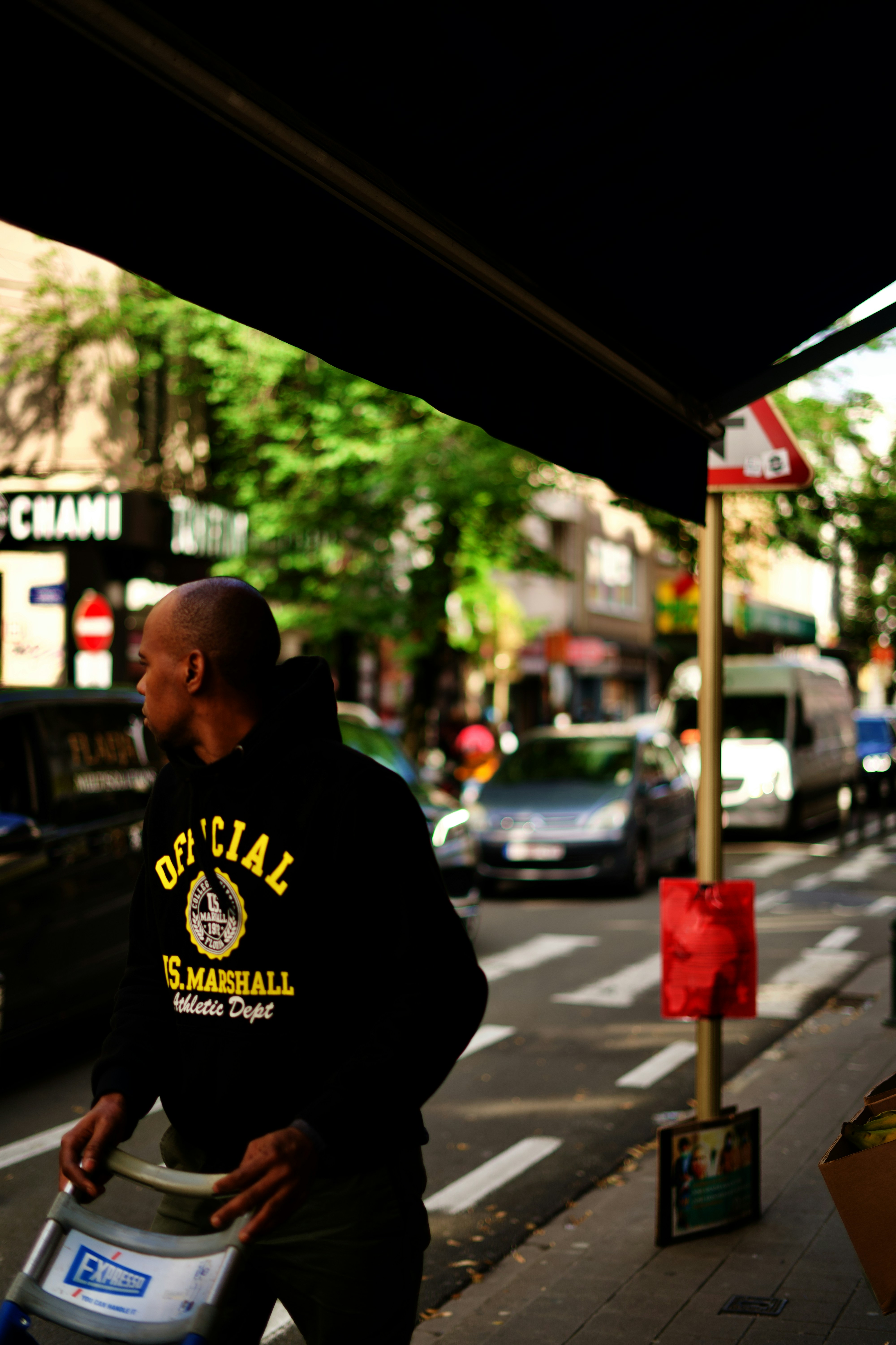 Hooded Messenger on a Moving City Block