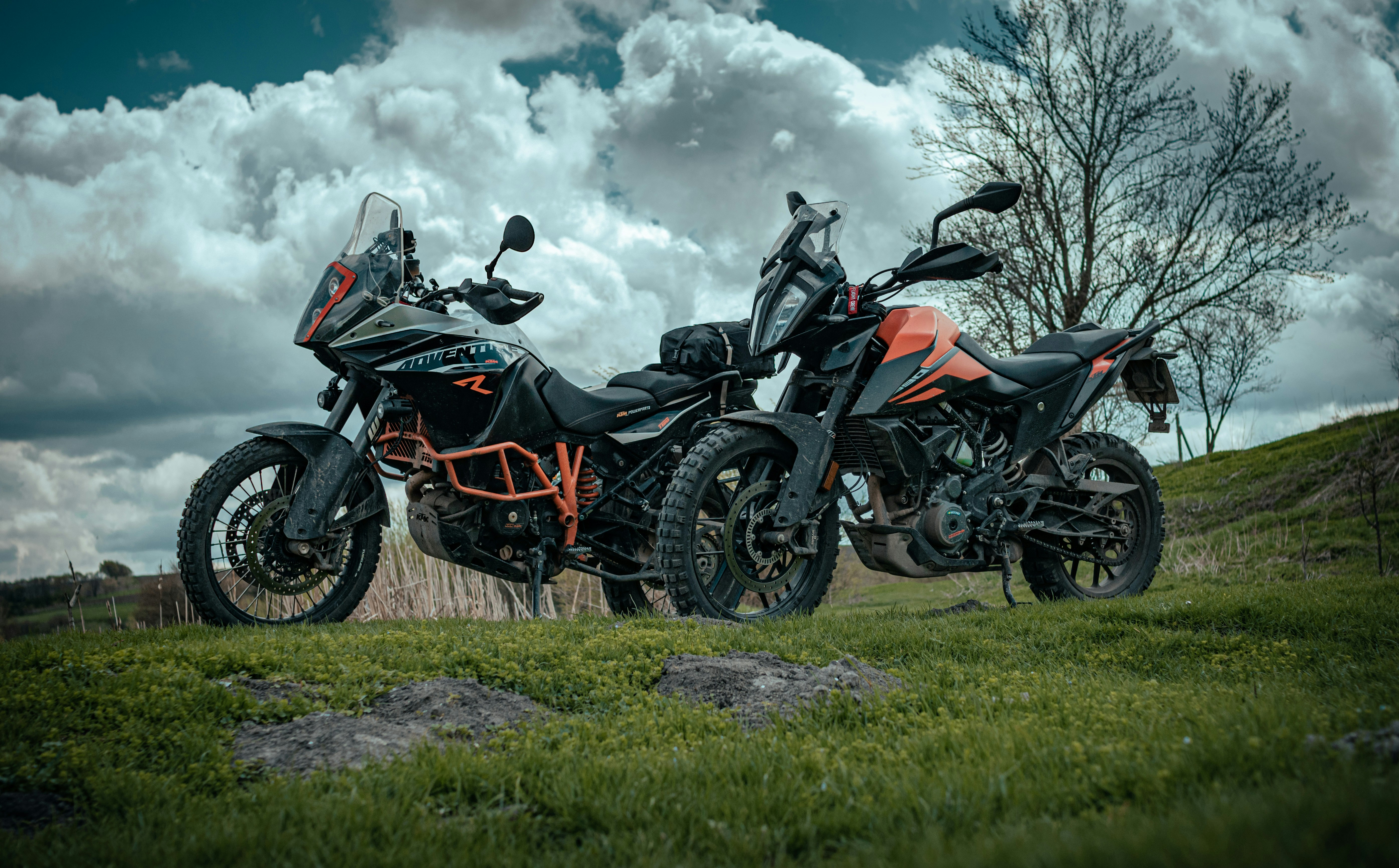 Black and red sports bike on green grass field under blue sky during ...