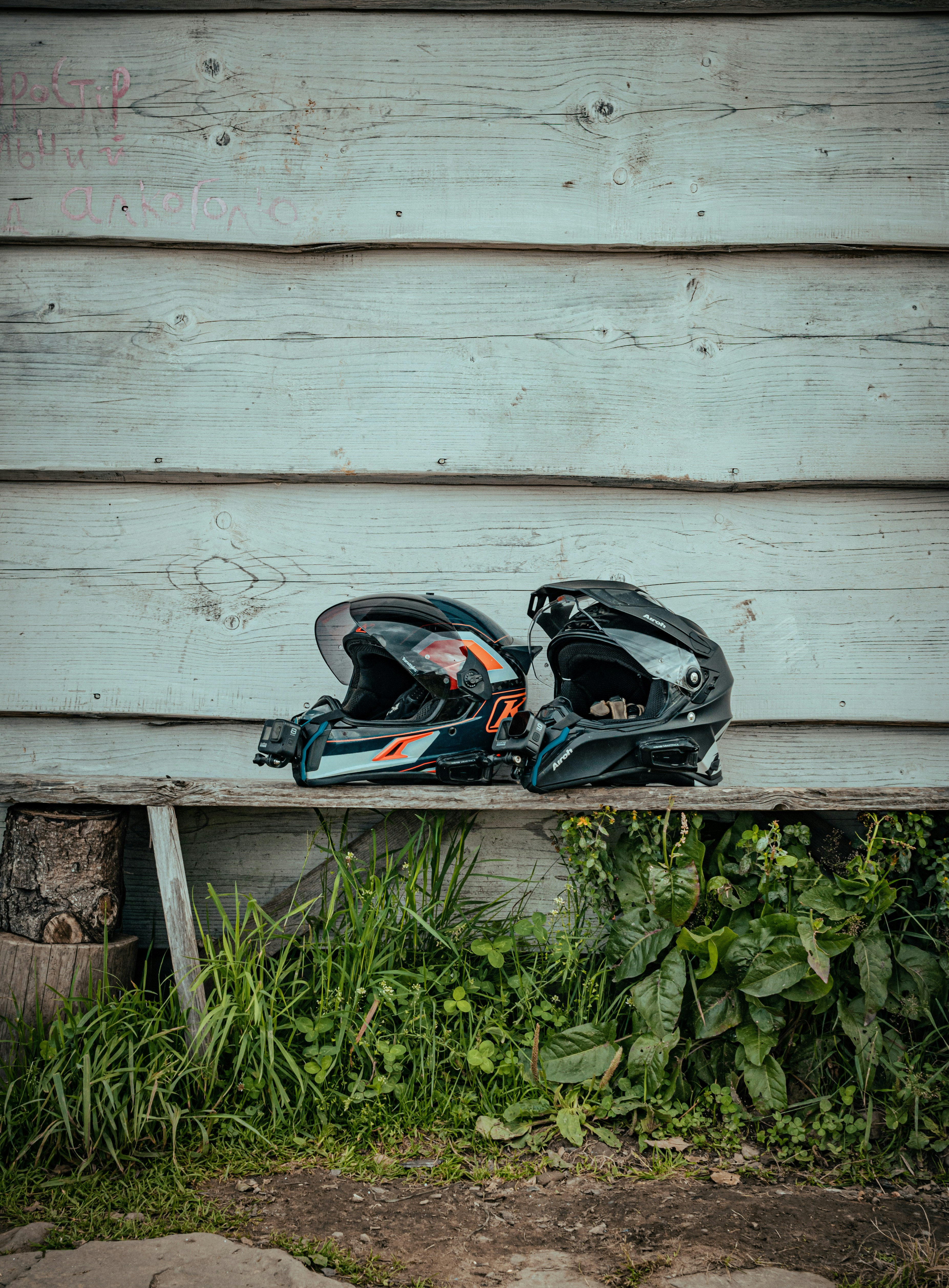Two Helmets Rest on a Weathered Wooden Wall
