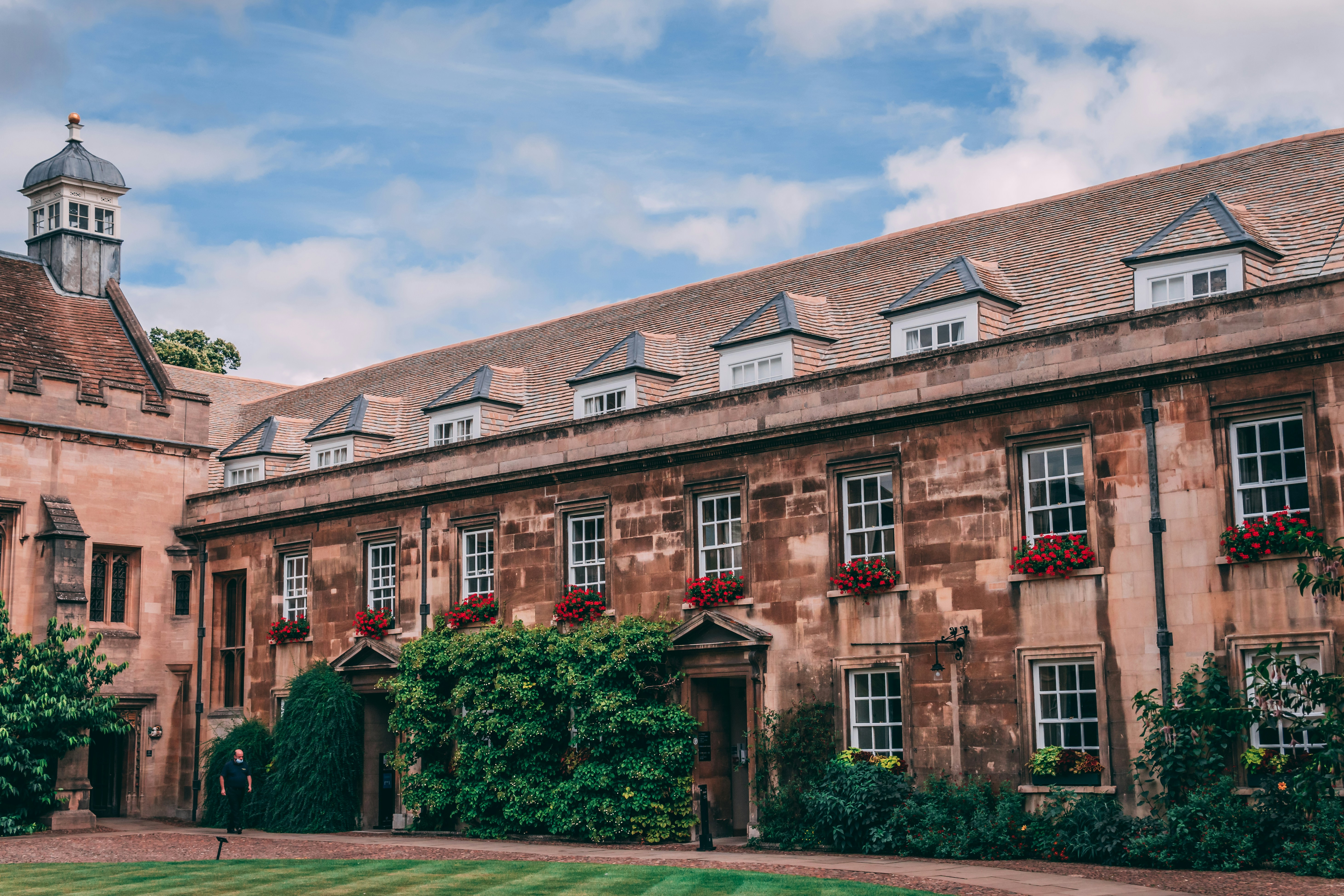 Historic building adorned with vibrant flower boxes and lush greenery, showcasing architectural charm and inviting atmosphere.