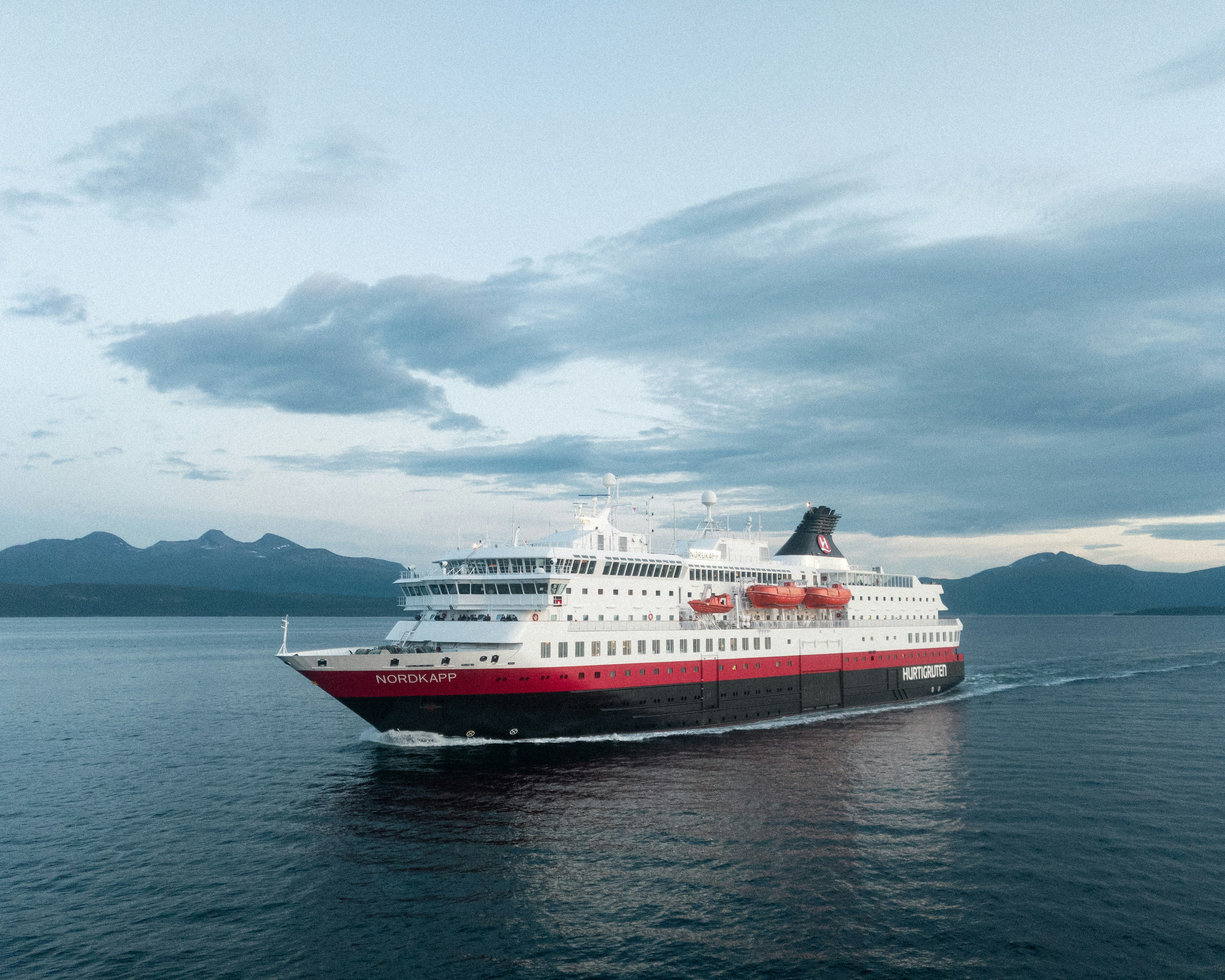 White and red cruise ship on sea under white clouds and blue sky during ...