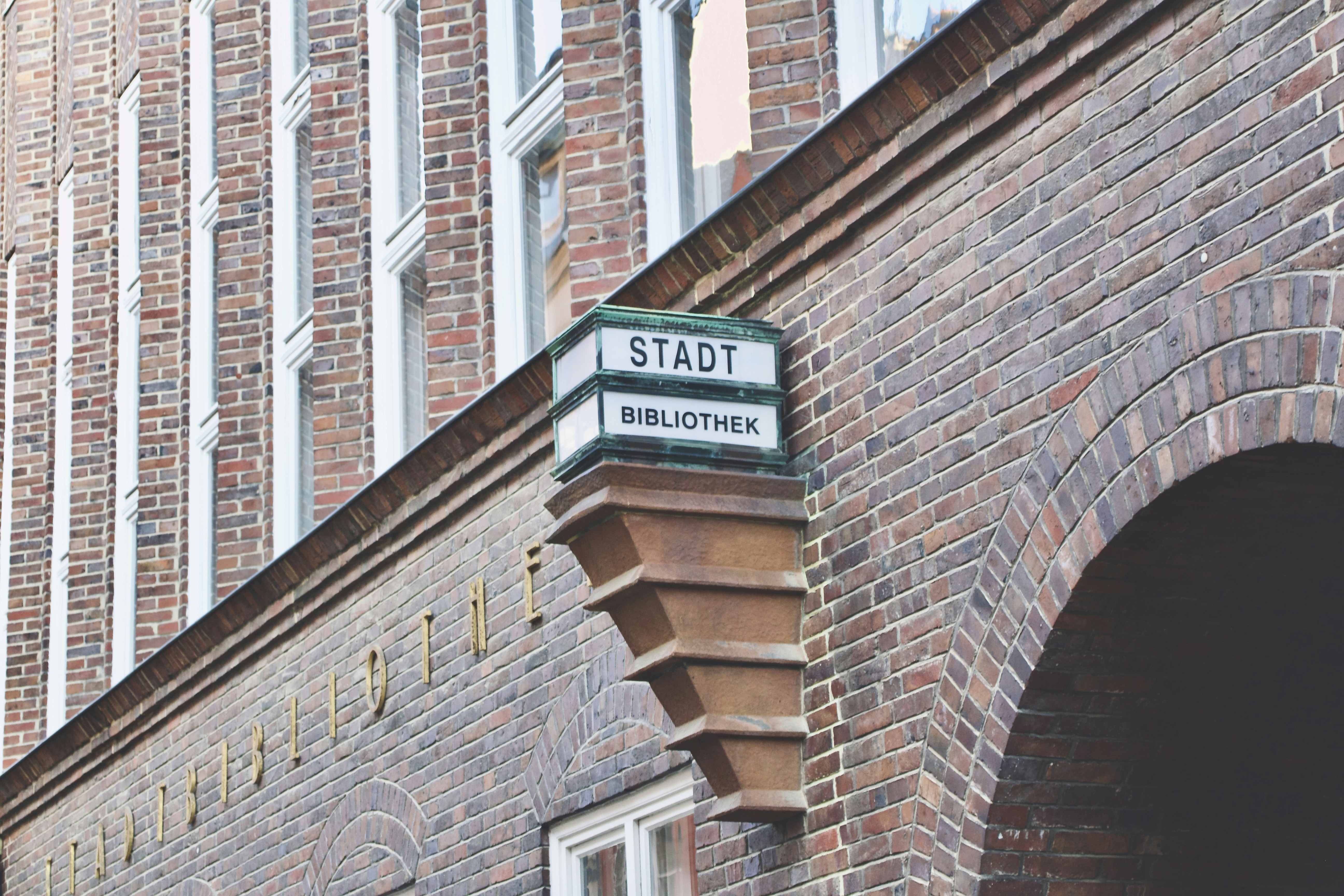 Brown brick building with white and blue signage photo – Free Lübecker ...