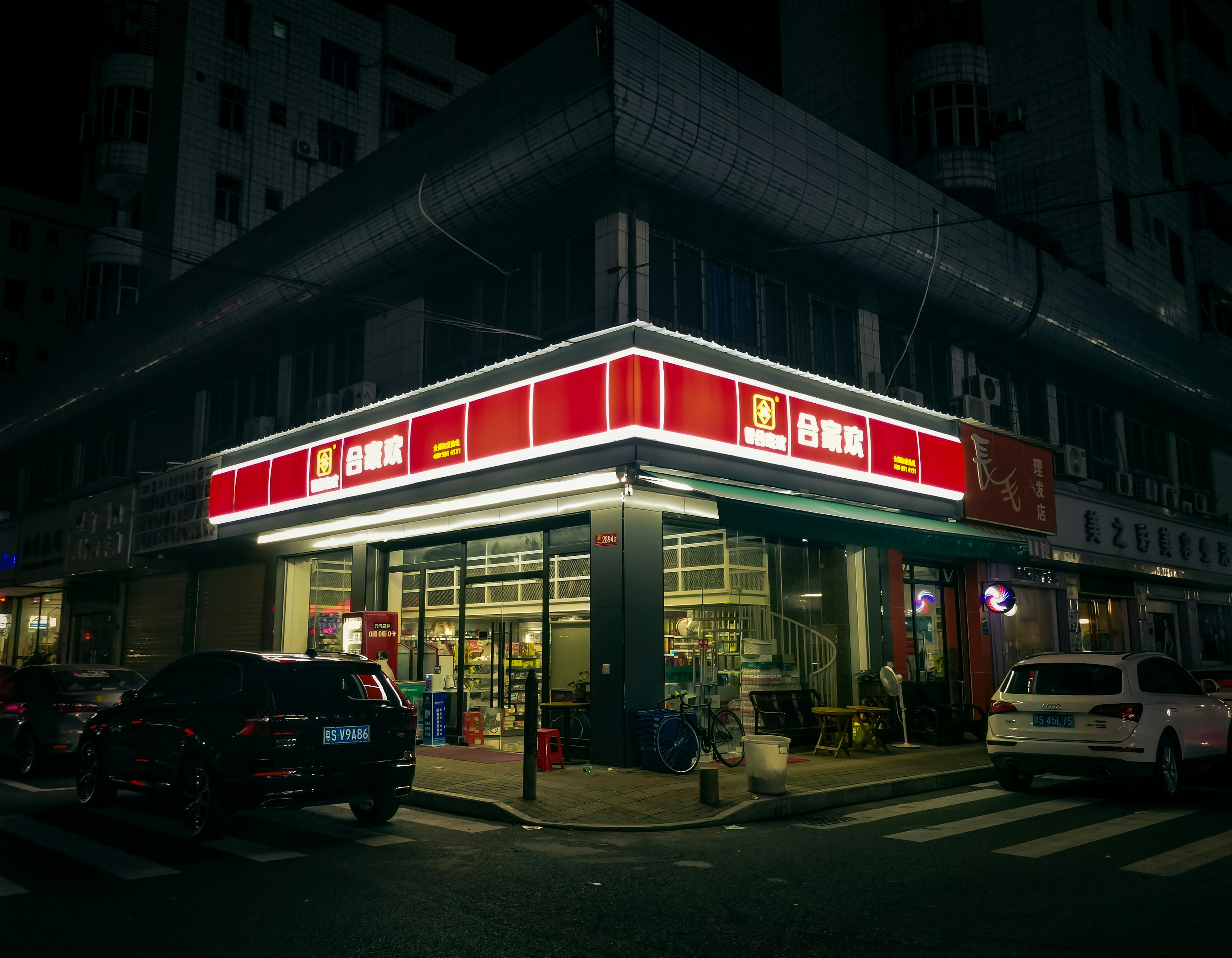 Crimson Neon Corner Store Basks in Quiet Night Traffic