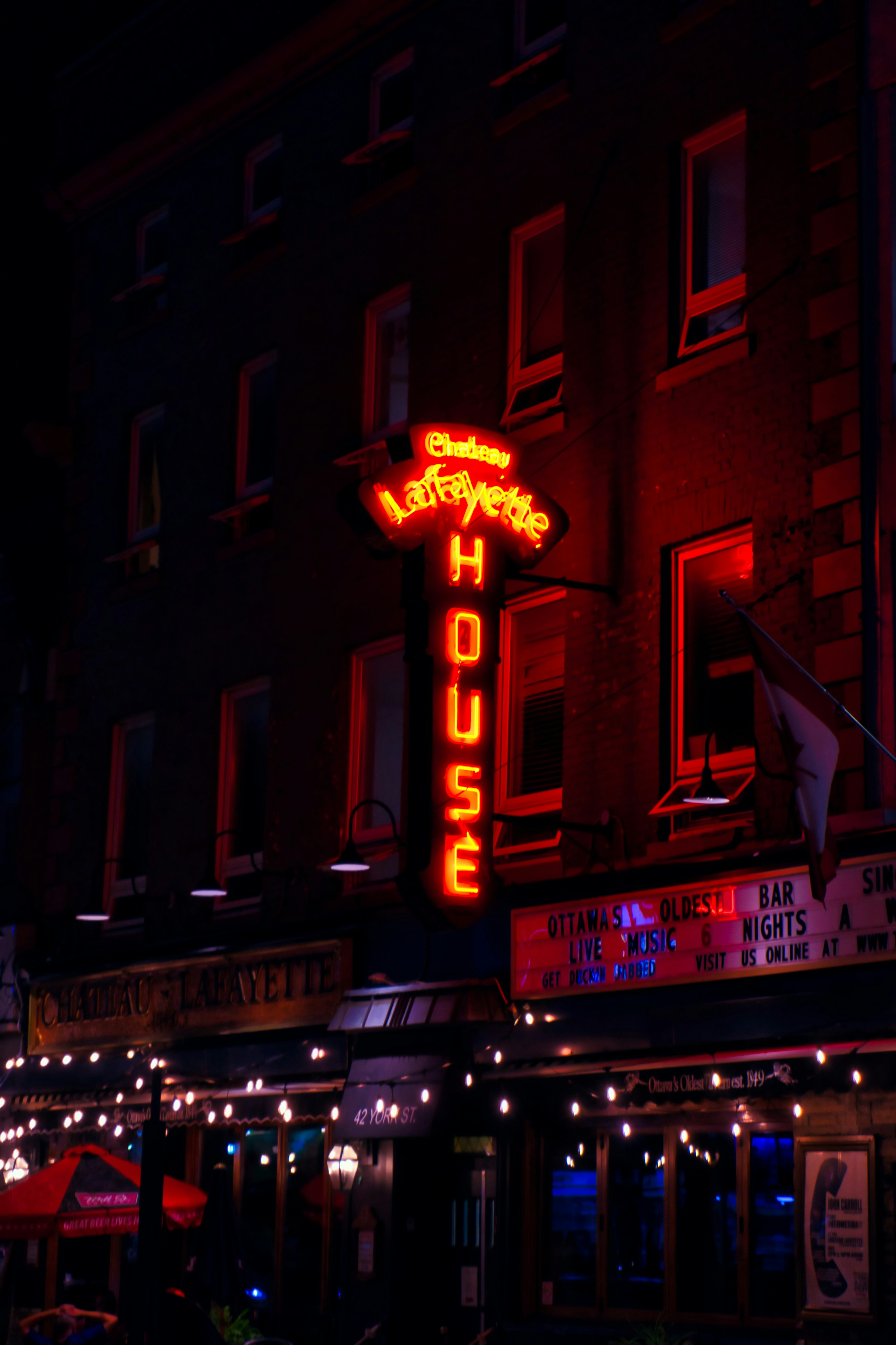 Lafayette House Neon Glow: Red Vertical Sign Illuminates a Night Street