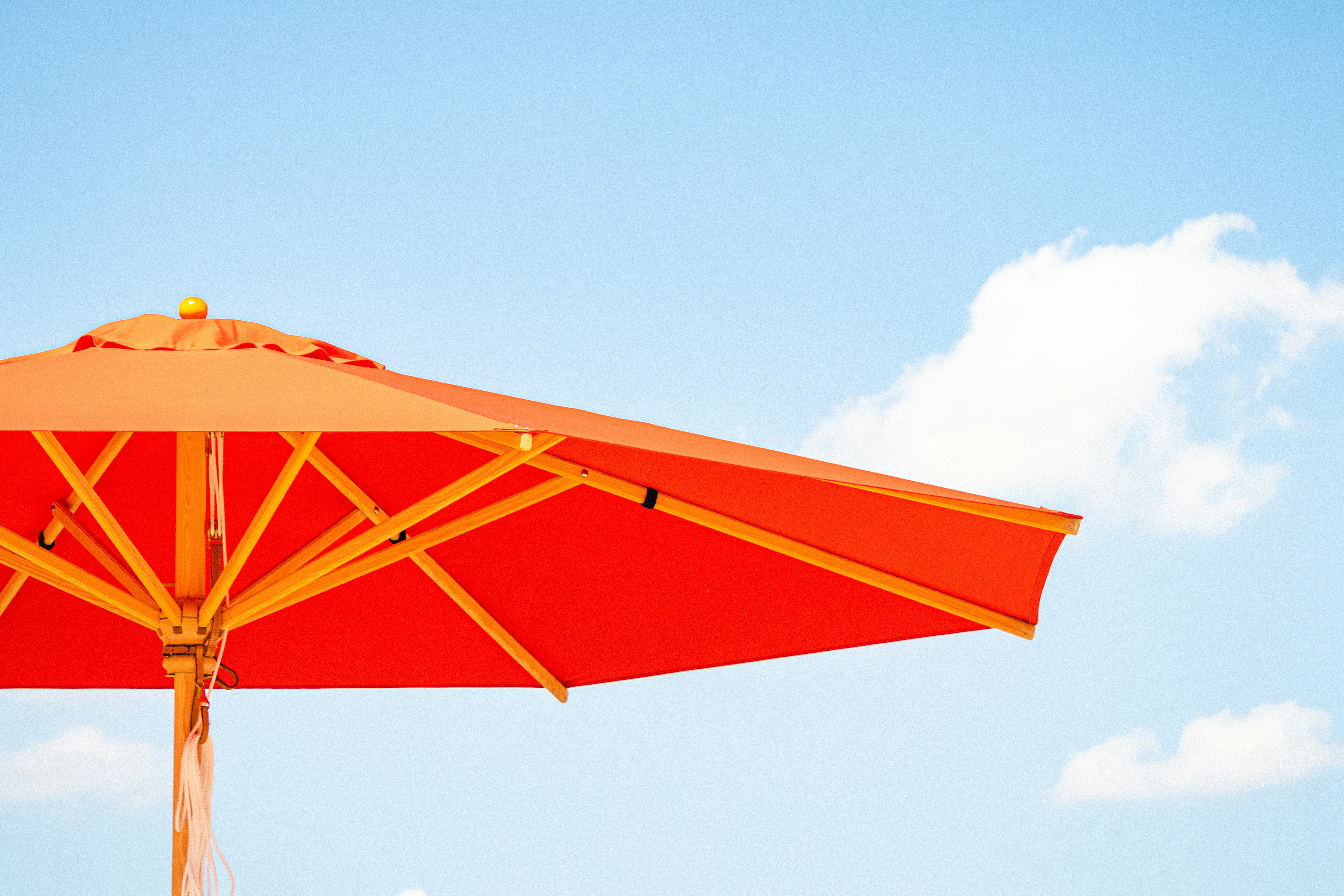 Orange parasol against a bright coastal sky
