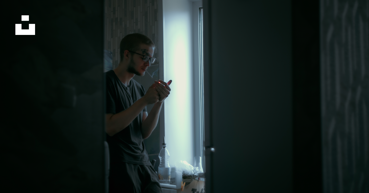 Man In White T Shirt And Gray Pants Standing Beside White Wooden Door