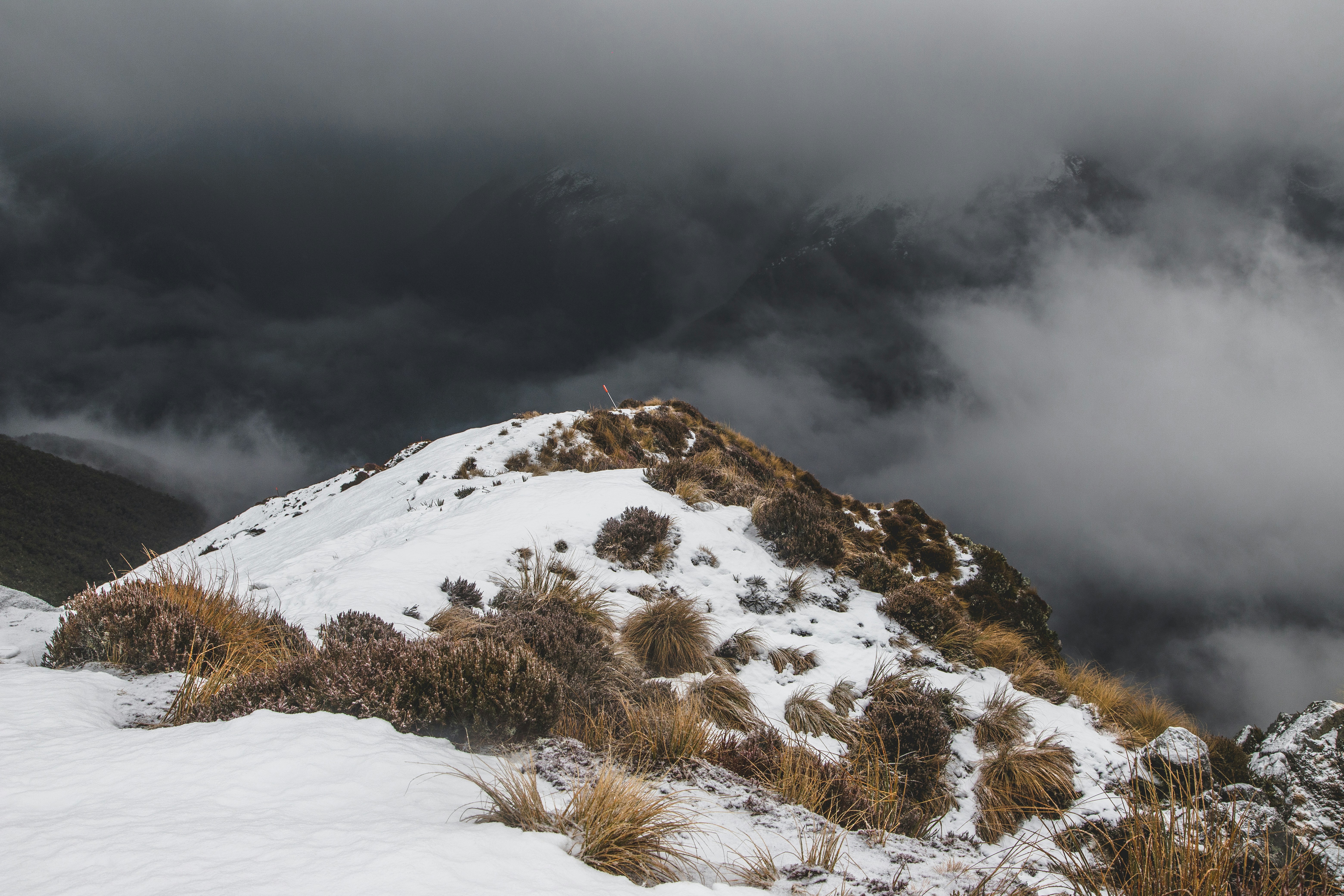 Snow-Dusted Ridge Confronts a Sky of Shadowed Clouds