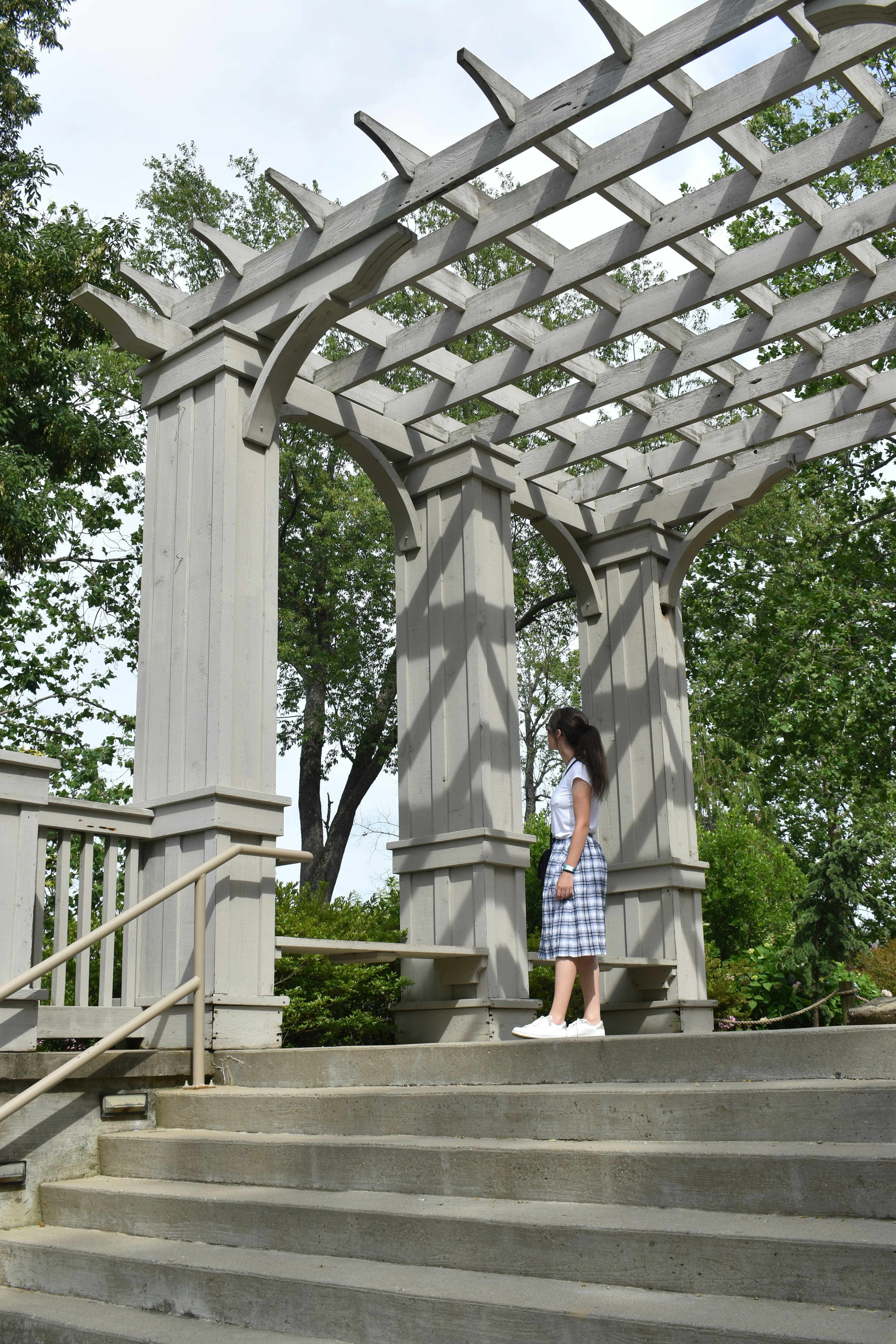 woman in white and blue dress standing on white concrete stairs during daytime