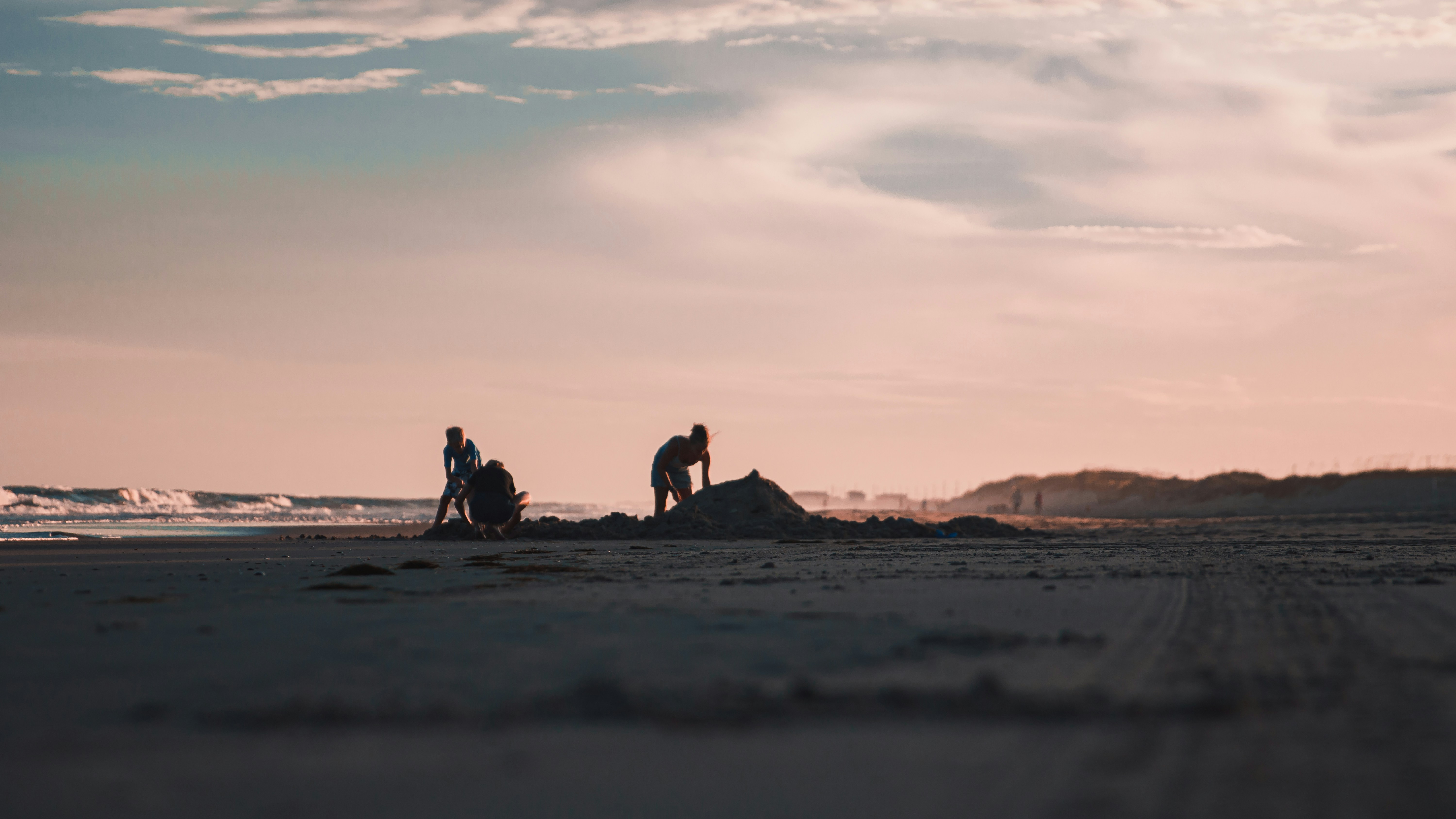 Distant Beach Workers at Dusk: silhouettes against a pastel海 sky