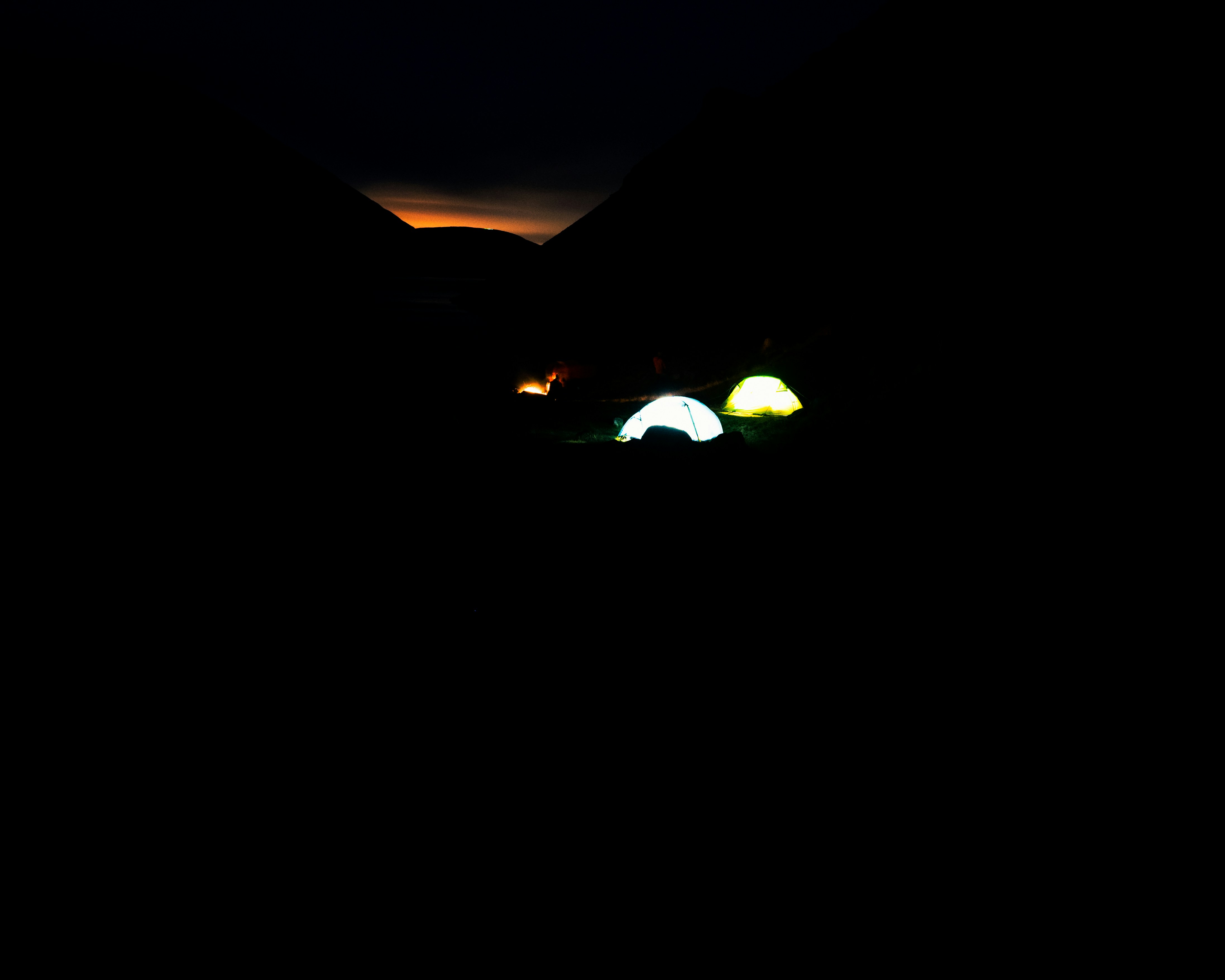 Whispering Ridge Camp: Glowing Tents Beneath a Distant Ember Sky