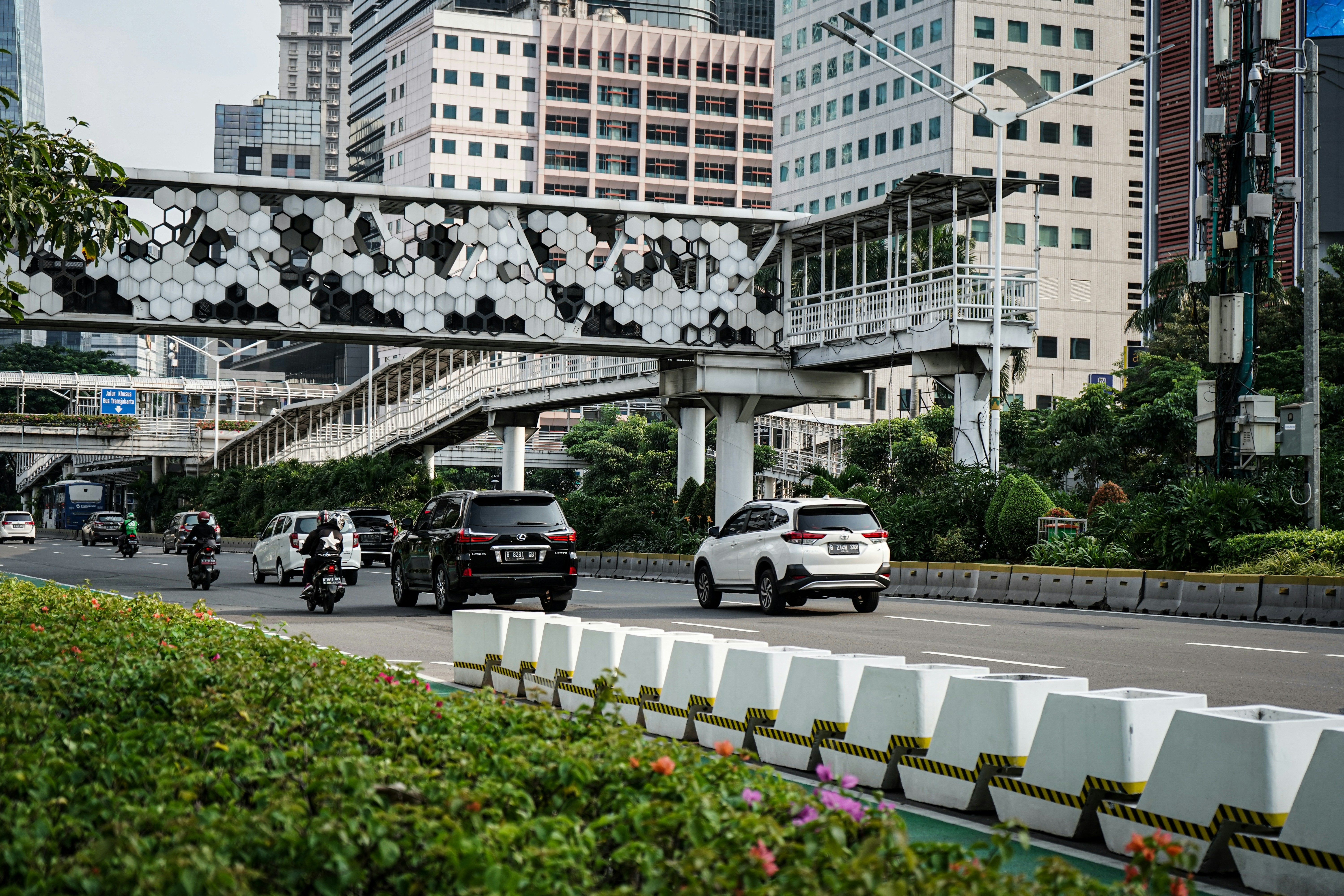 Modern overpass adorned with geometric patterns above a busy street, showcasing the harmony between architecture and urban life.