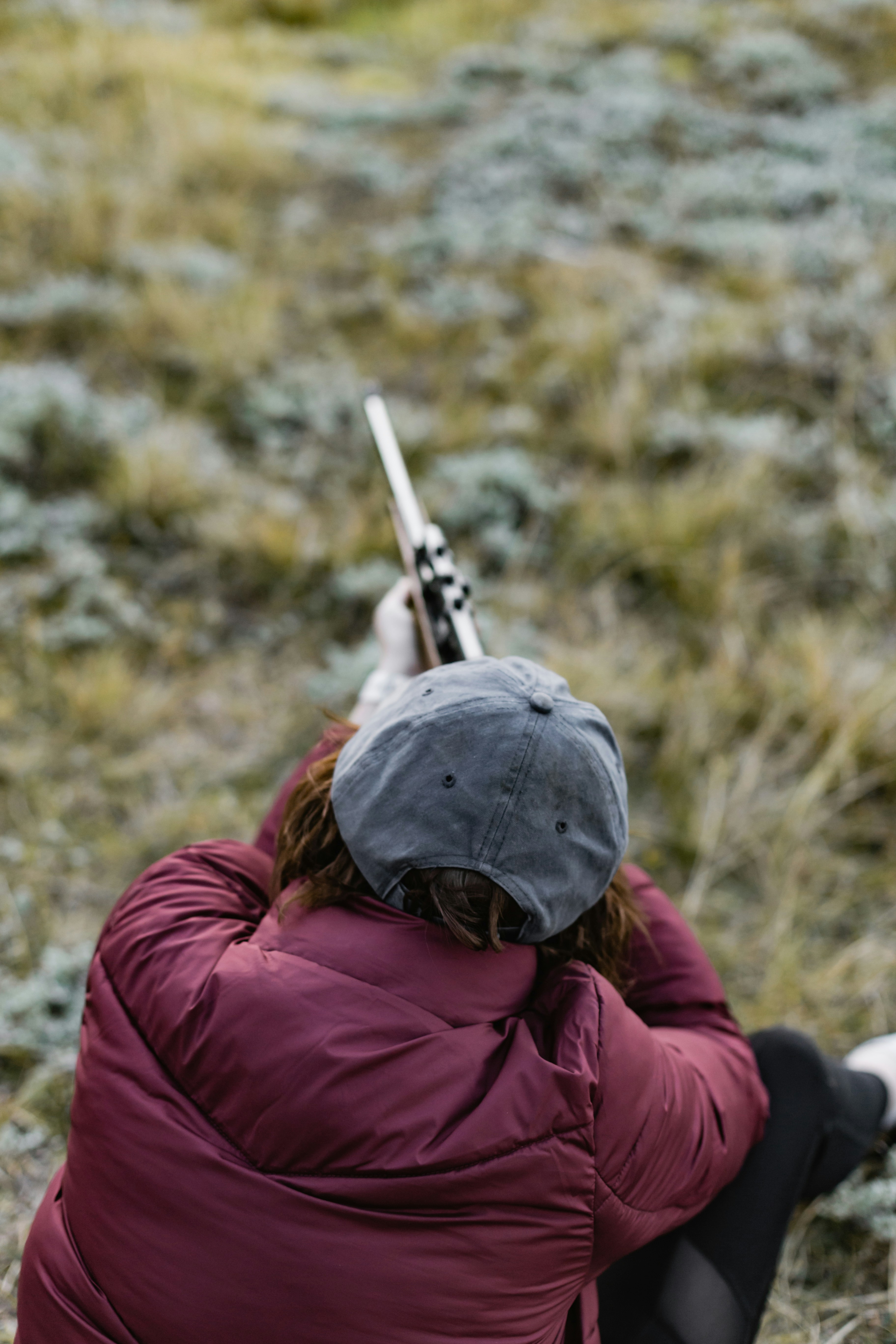 Foto Persona con chaqueta roja con gorra negra sosteniendo rifle ...