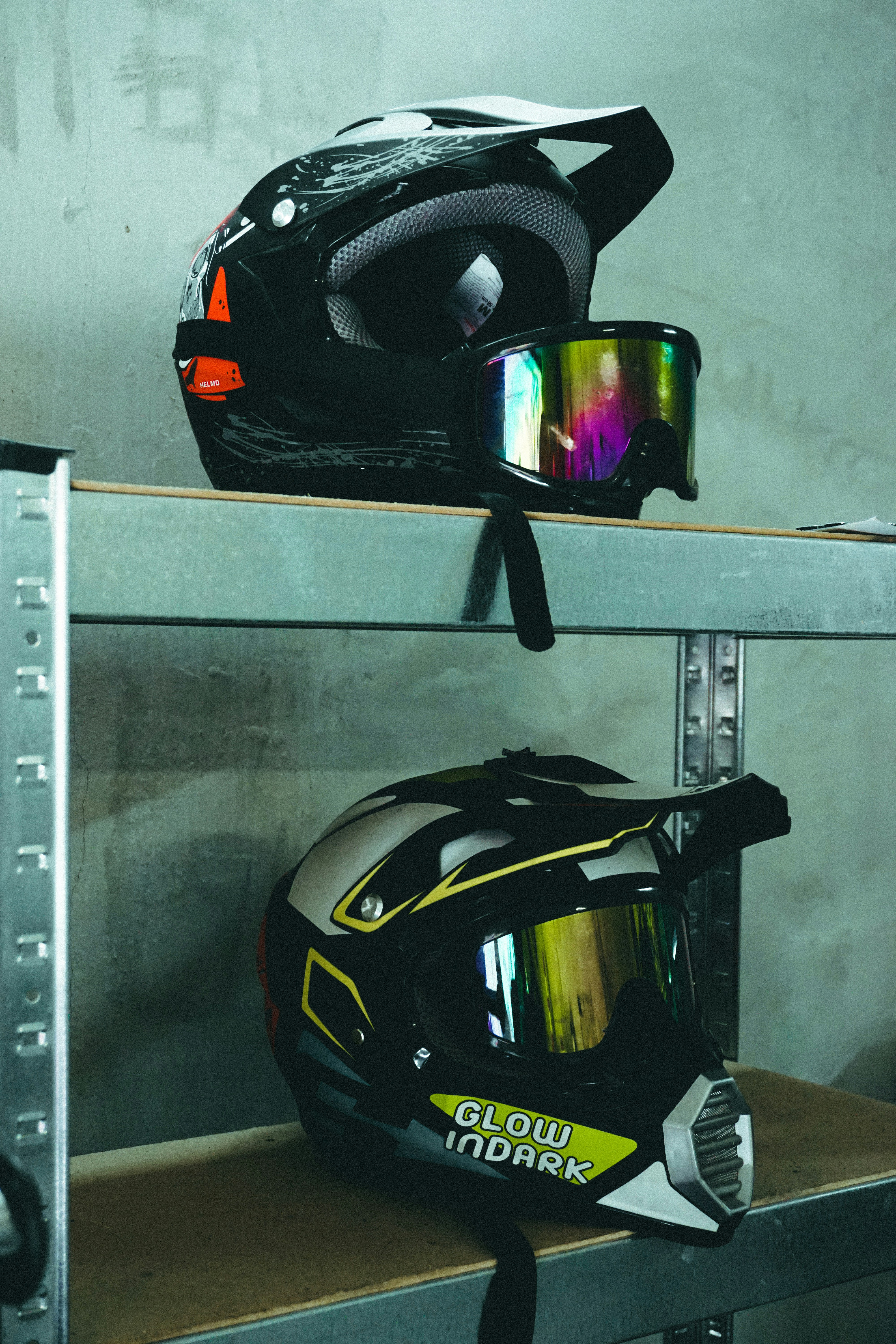 Iridescent Visor on an Industrial Shelf: Dual Helmets in Quiet Focus