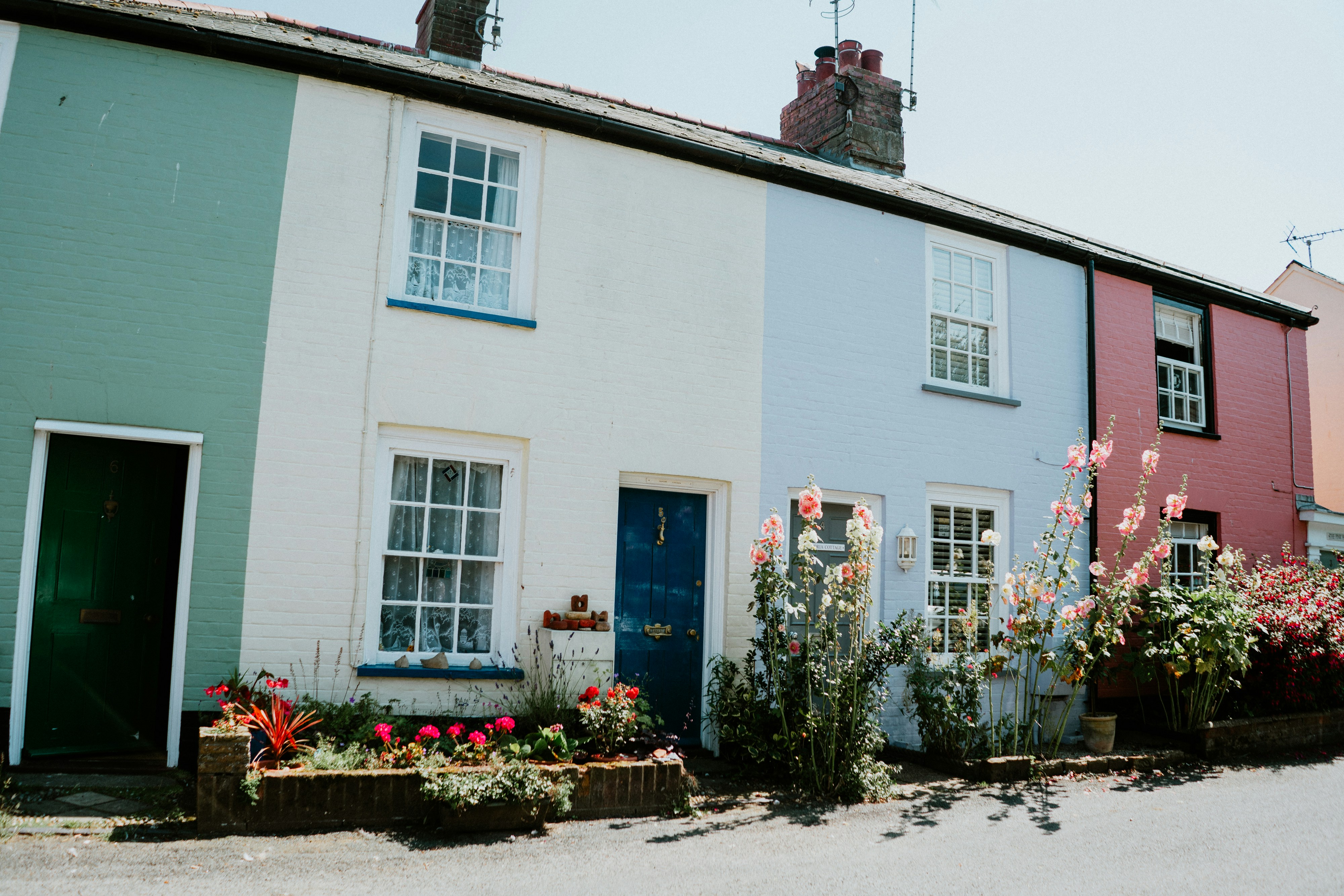 Colorful row of traditional houses adorned with vibrant flowers and greenery, showcasing a picturesque village scene.