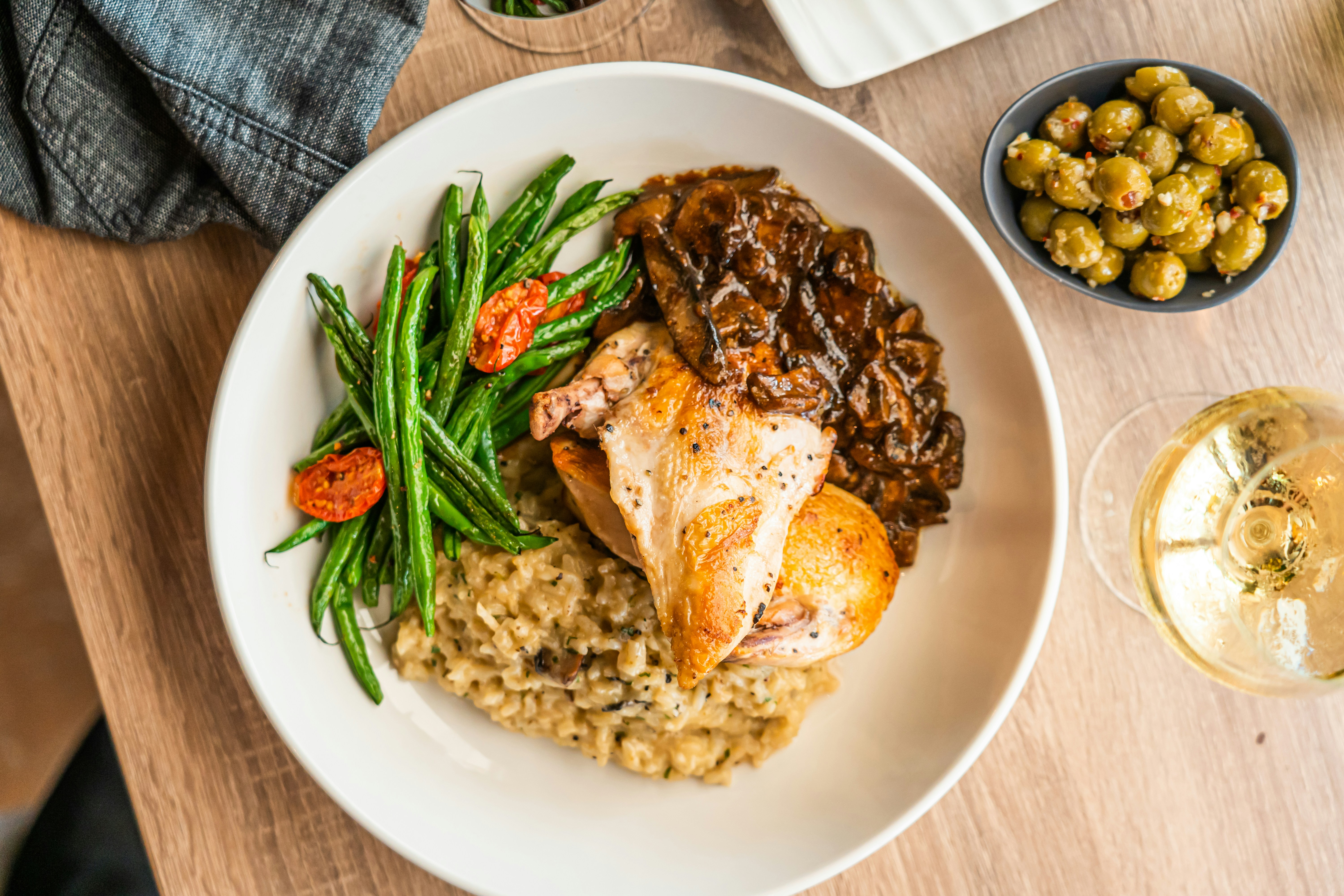 Plate of Roast Chicken with Green Beans, Risotto, and Roasted Tomatoes