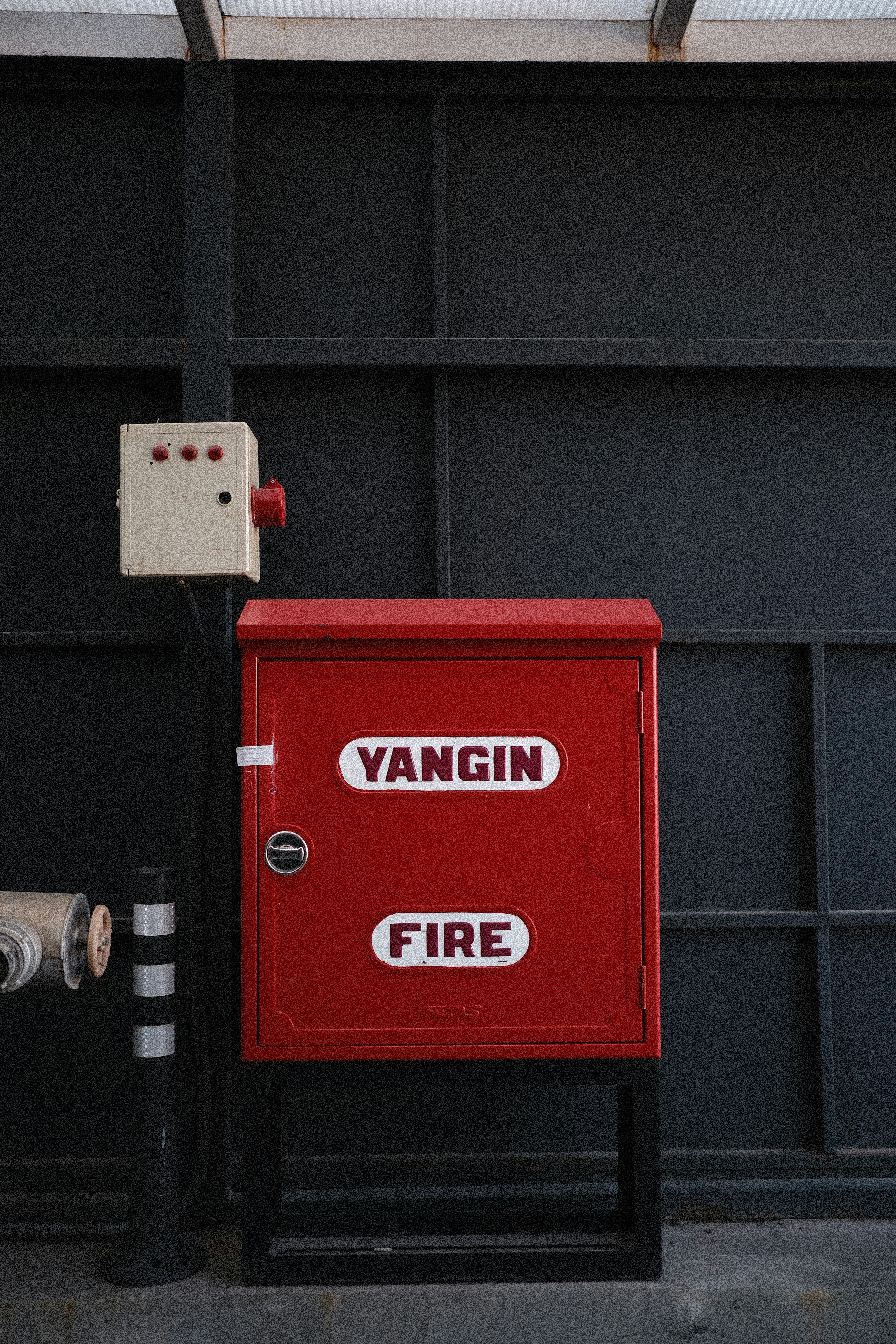Yangin Fire Cabinet: Crimson Core on a Monochrome Industrial Backdrop