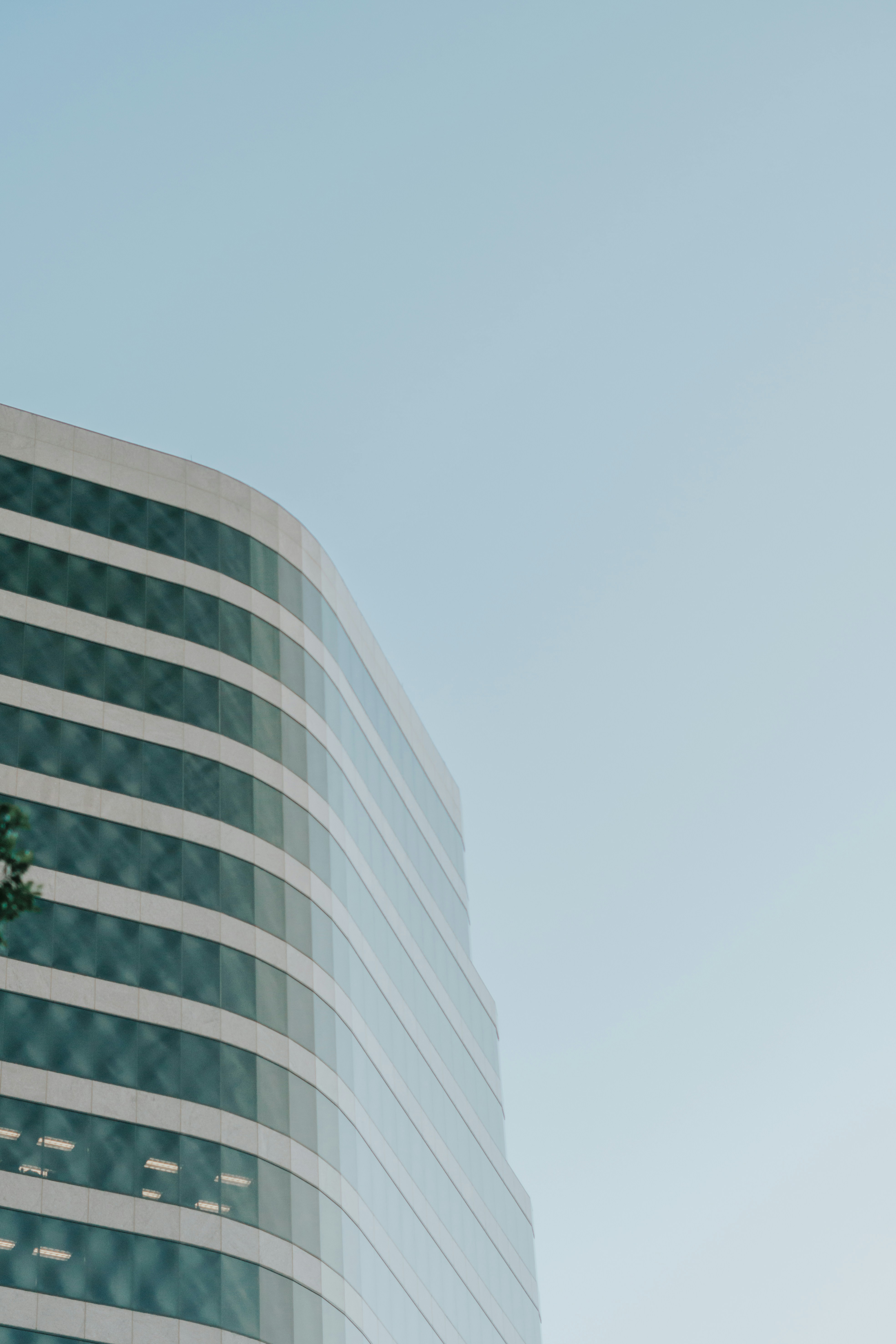 Cornered Glass Curve: A Modern Facade Against an Open Sky
