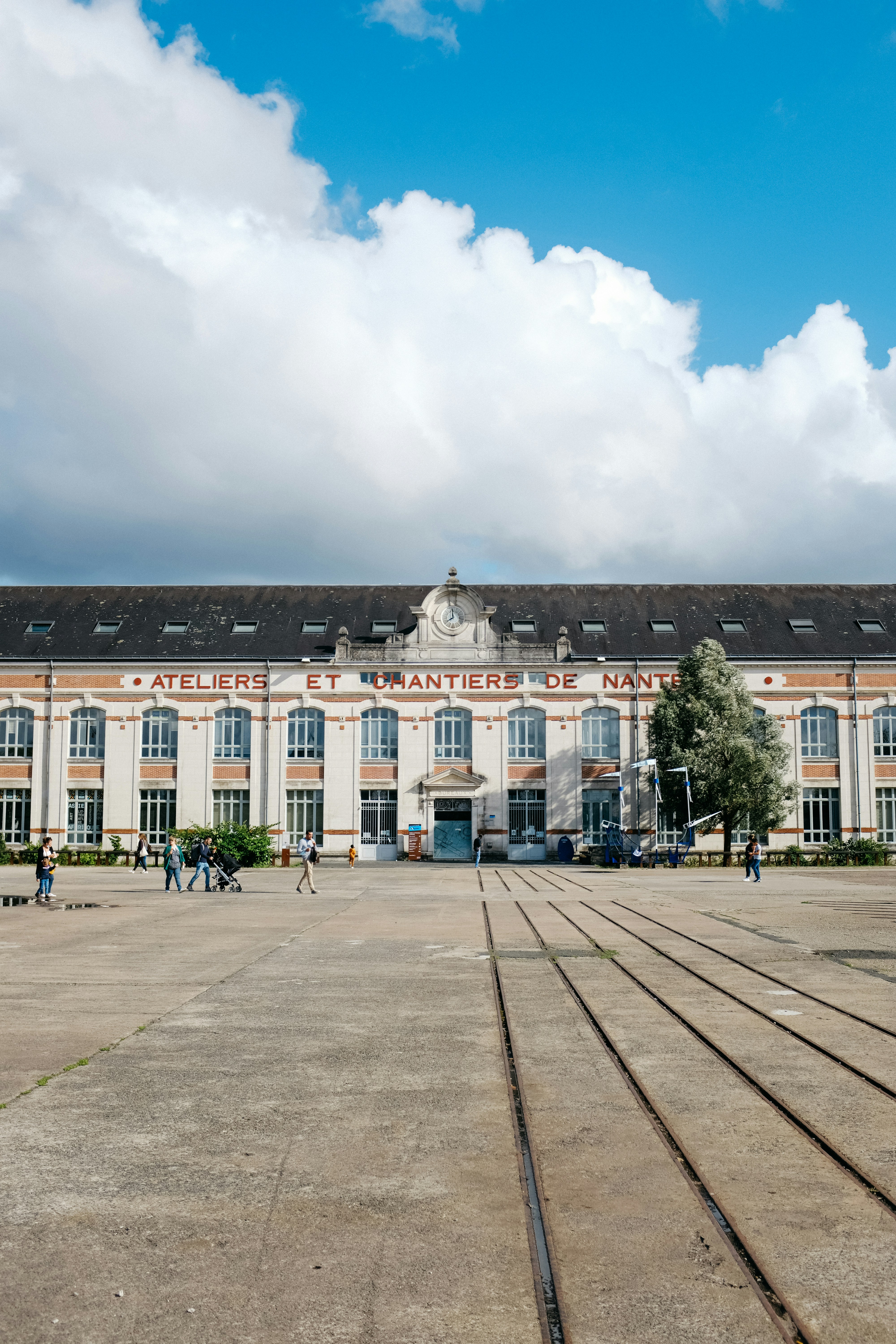 Rails Converge on a Sunlit Nantes Ateliers Facade