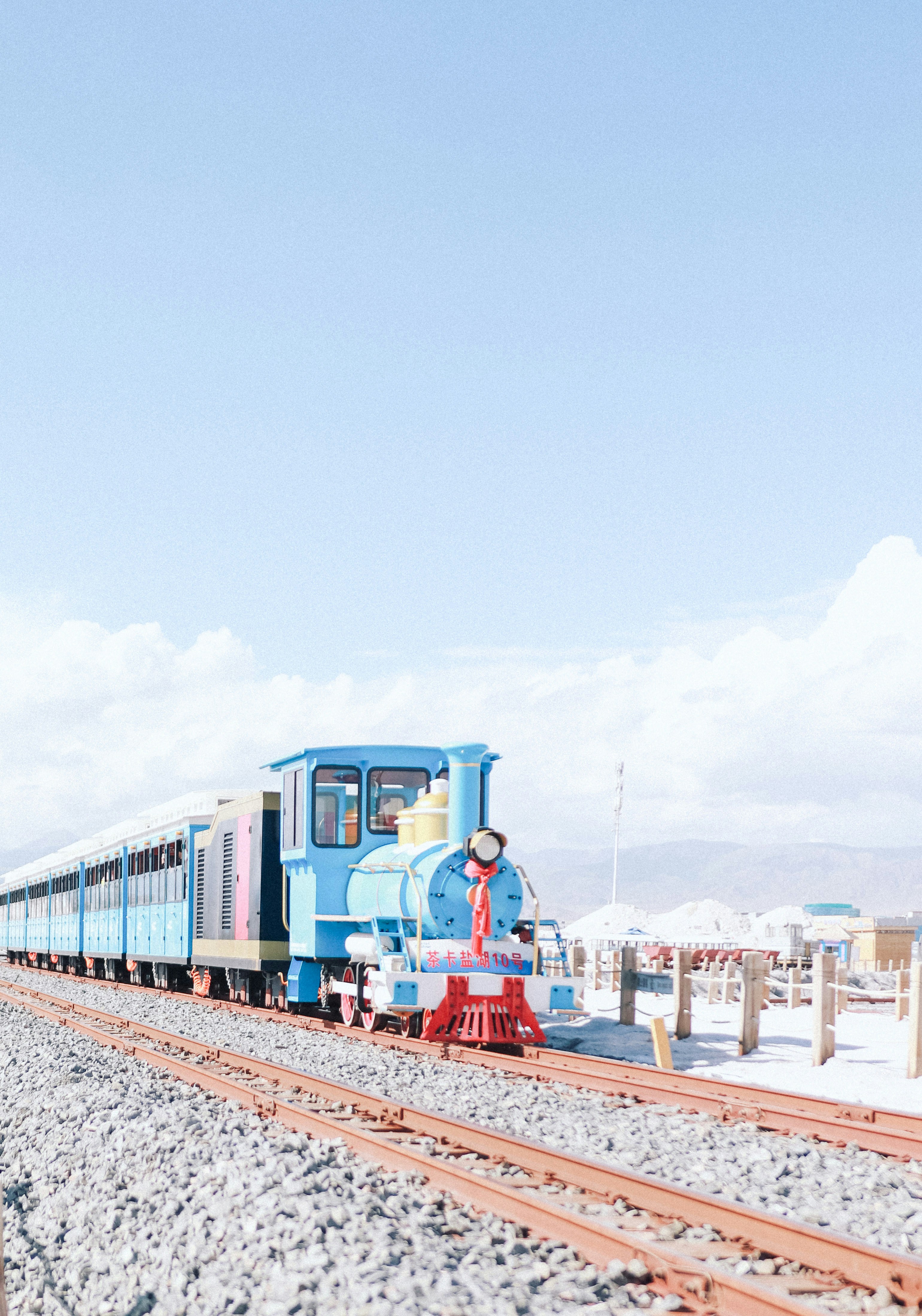 blue train on rail road during daytime