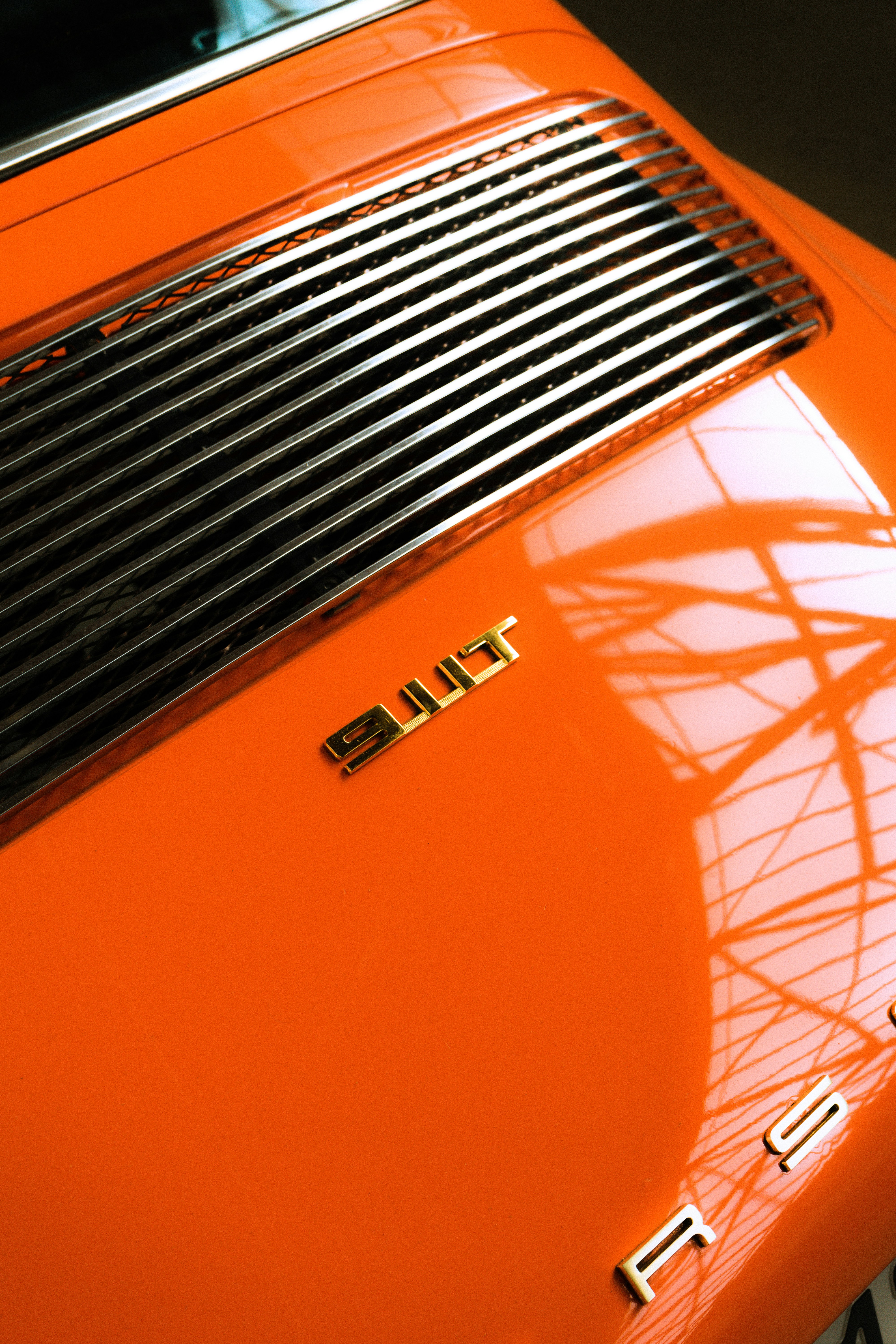 Burnt-Orange Swift Hood: Parallel Grilles and Polished Emblem