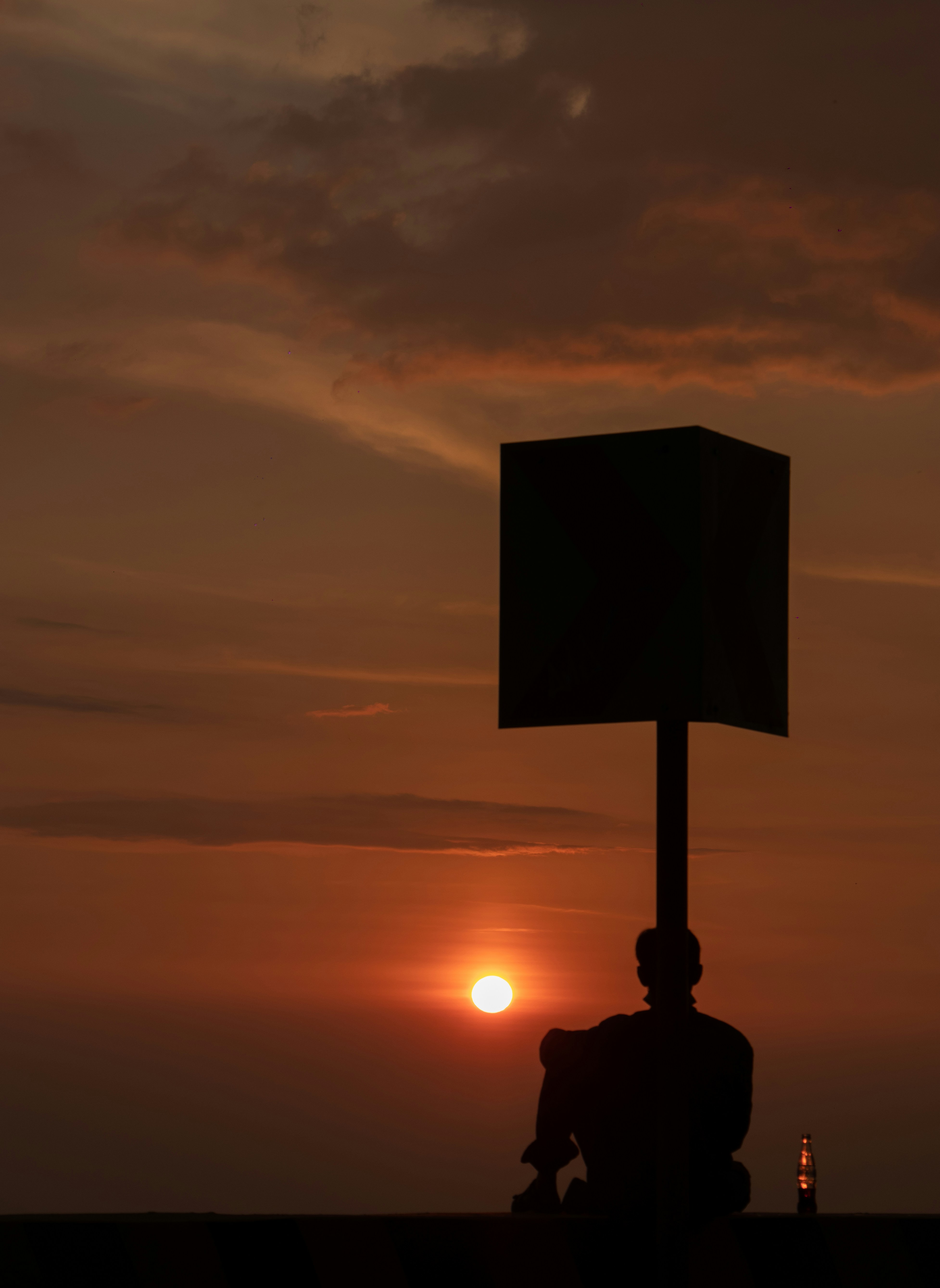 Silhouette at Sunset: A Rooftop Vigil Beneath the Sun