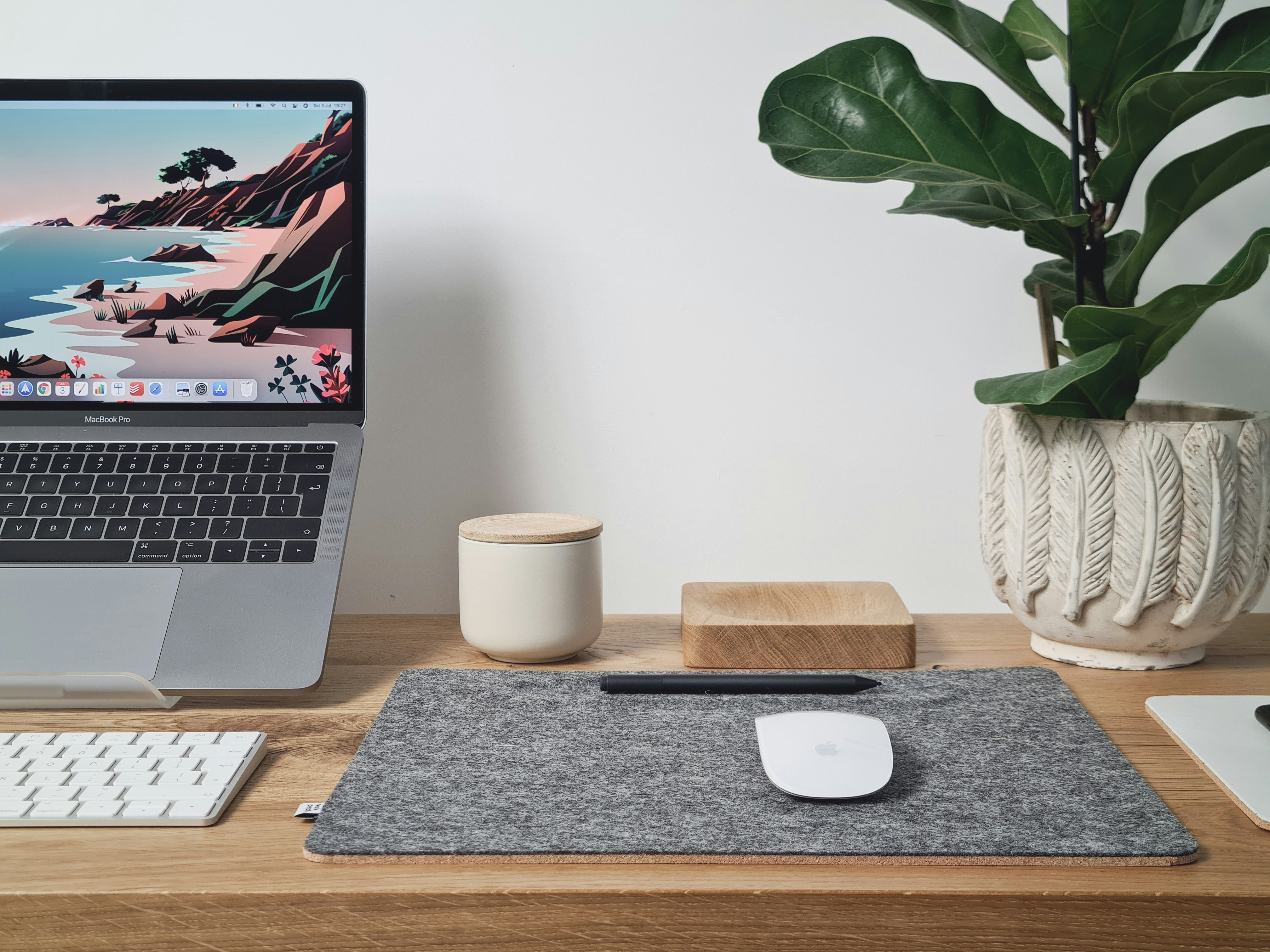 Macbook pro beside brown wooden chopping board and white ceramic mug on ...