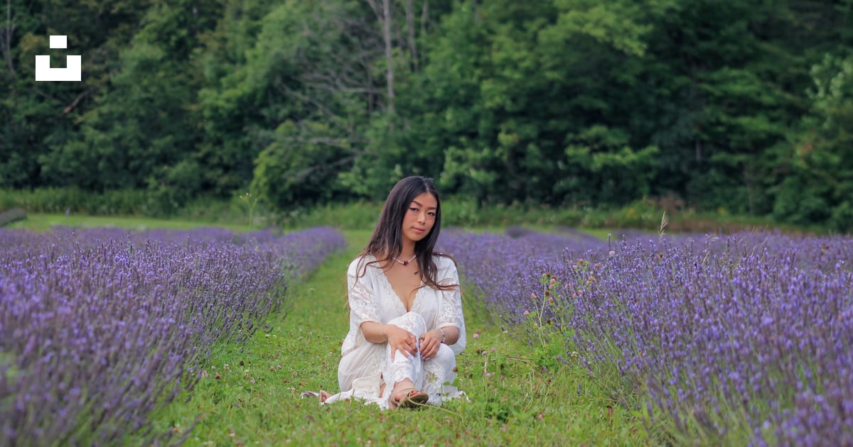 昼間、緑の芝生の上に座る白いドレスの女の子の写真 Unsplashの花の無料画像