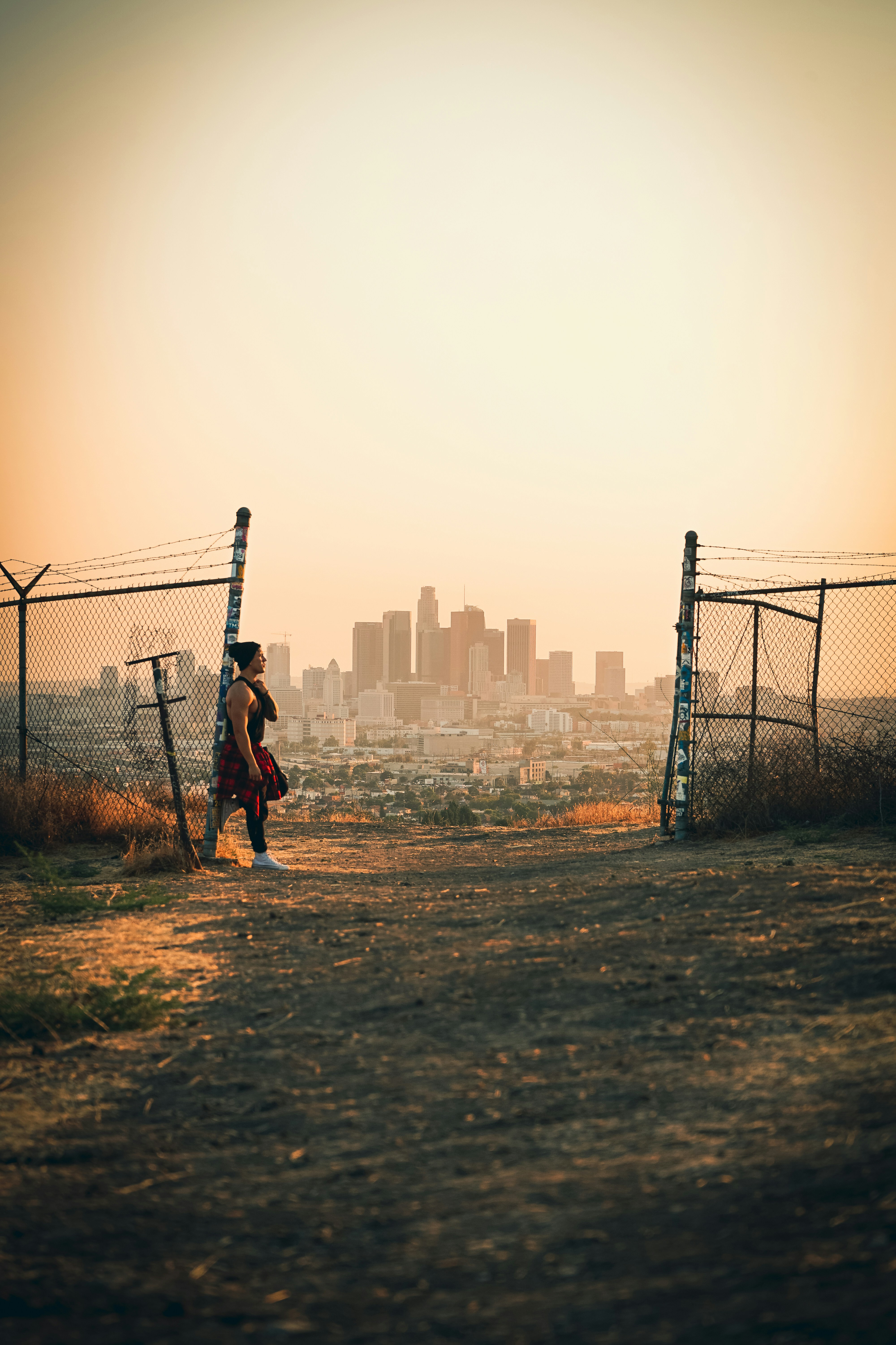 Horizon Gate: A lone climber at sunset near the city ridge
