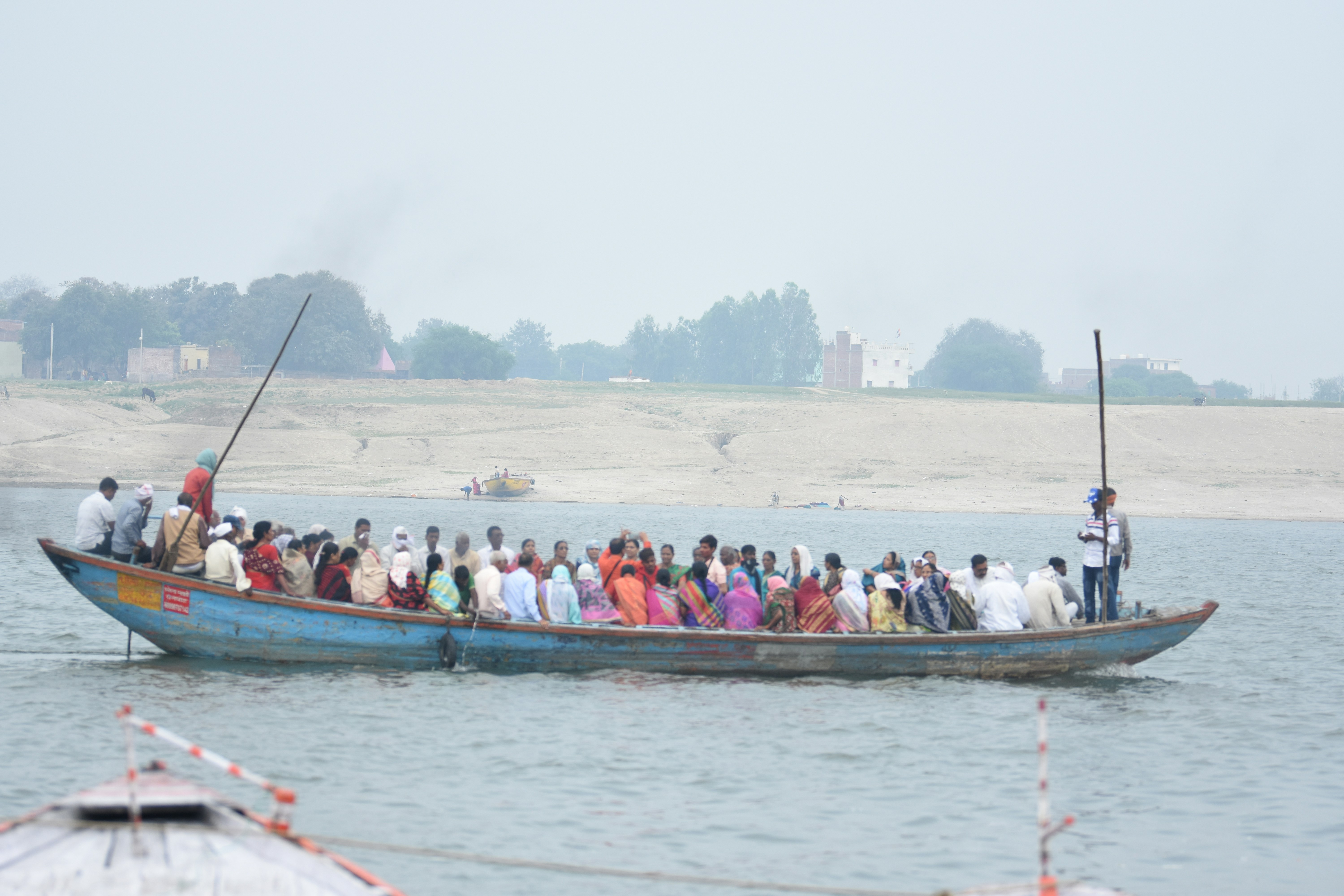 Dawn Mist Ferry: A Packed Long Boat Crossing the Quiet River