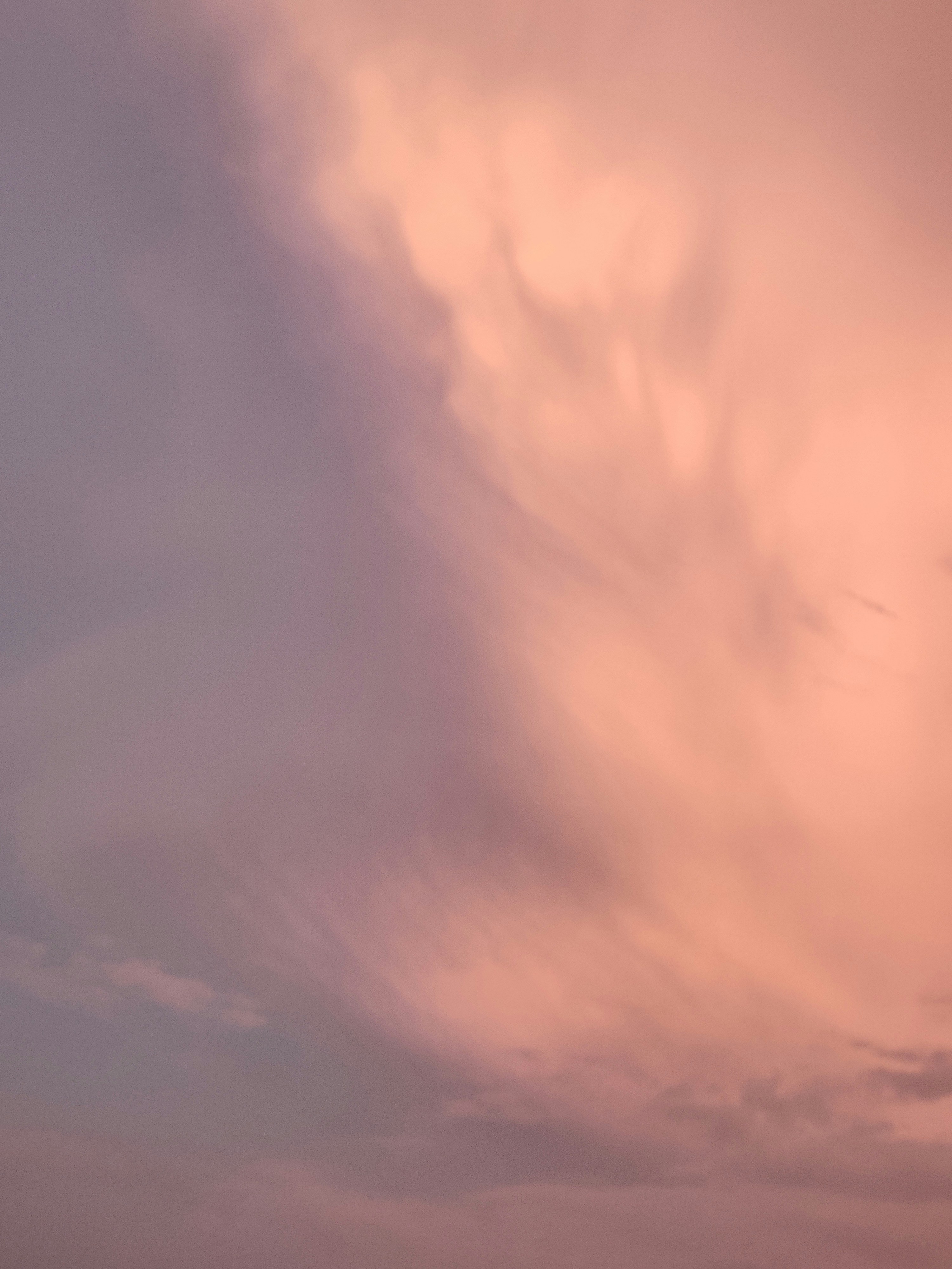 Soft pastel clouds merging in the evening sky, reflecting the gentle hues of twilight.