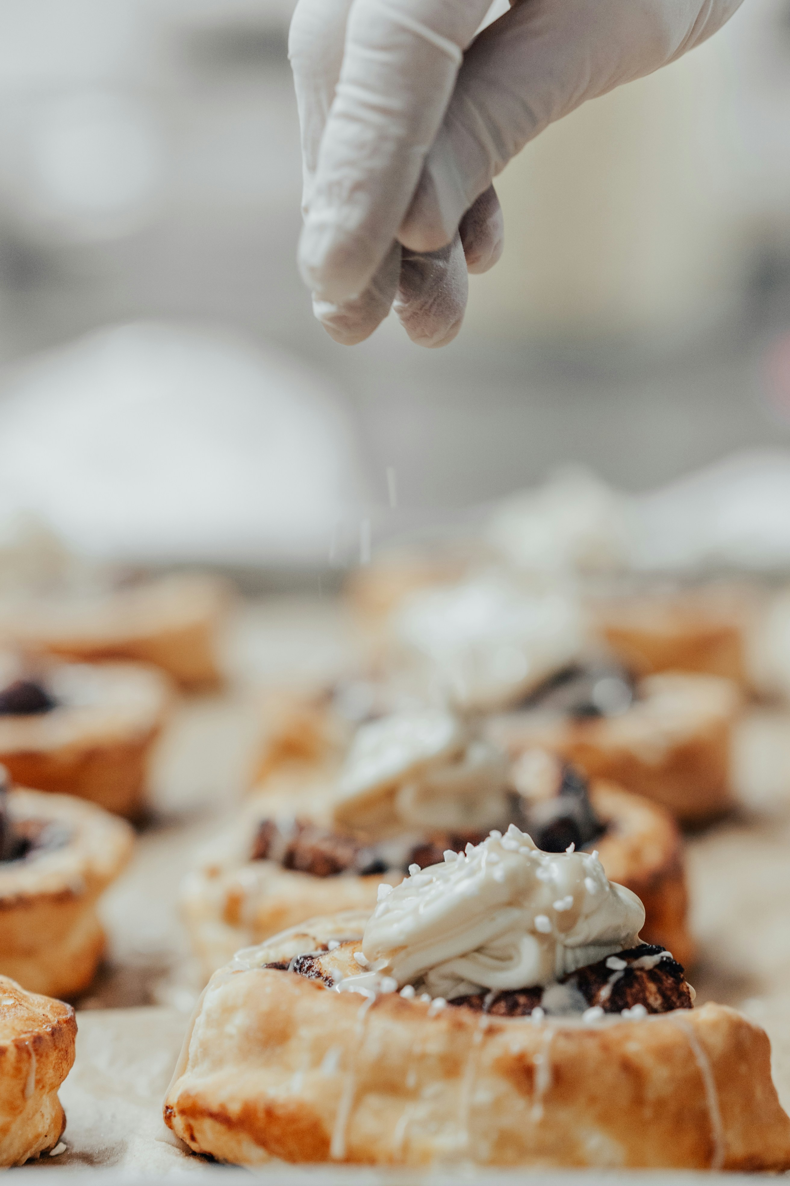 Hand is Sprinkling Sugar on Pastry Crowns