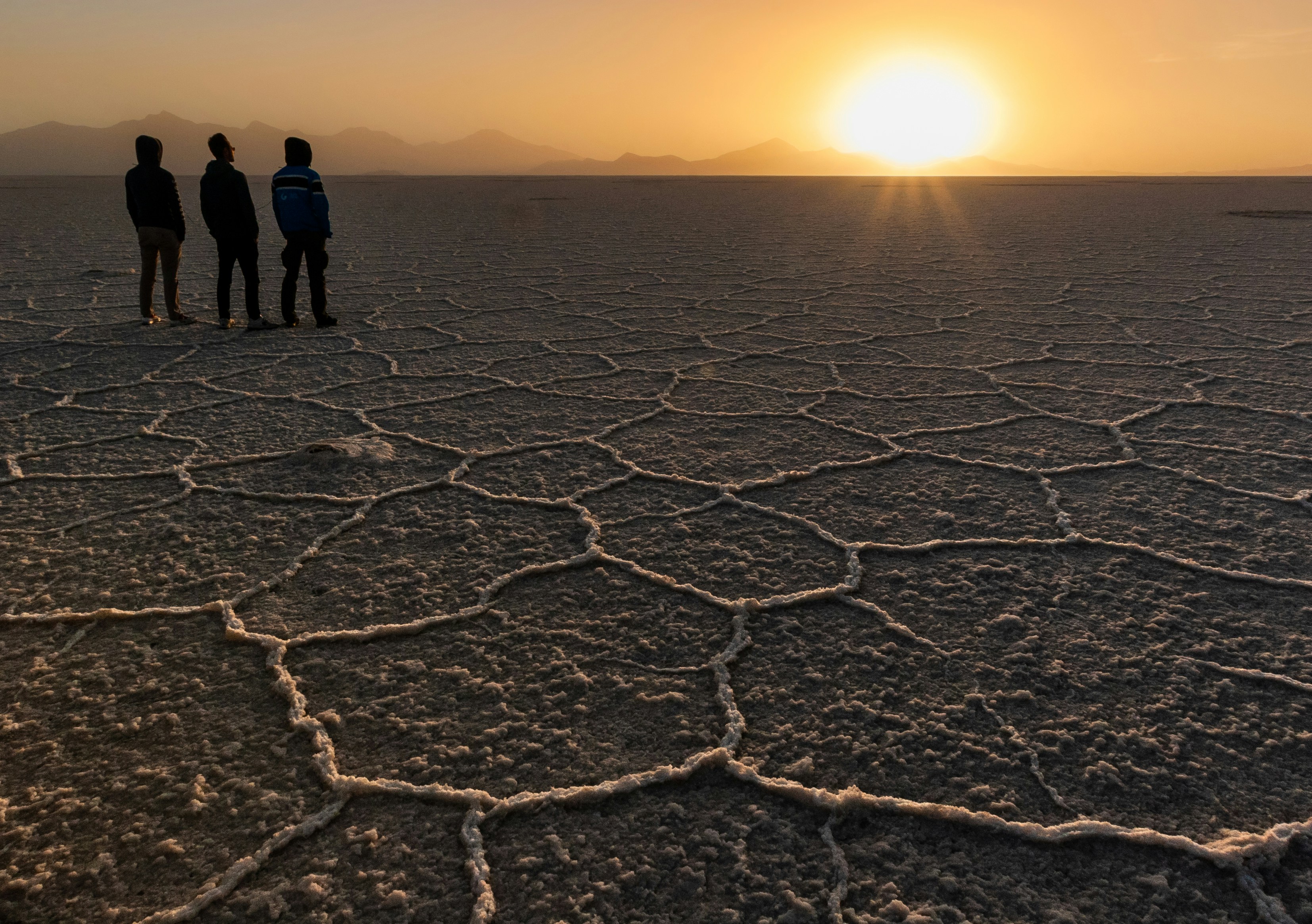 Silhouette de 2 personnes debout sur un sol rocheux pendant le coucher ...