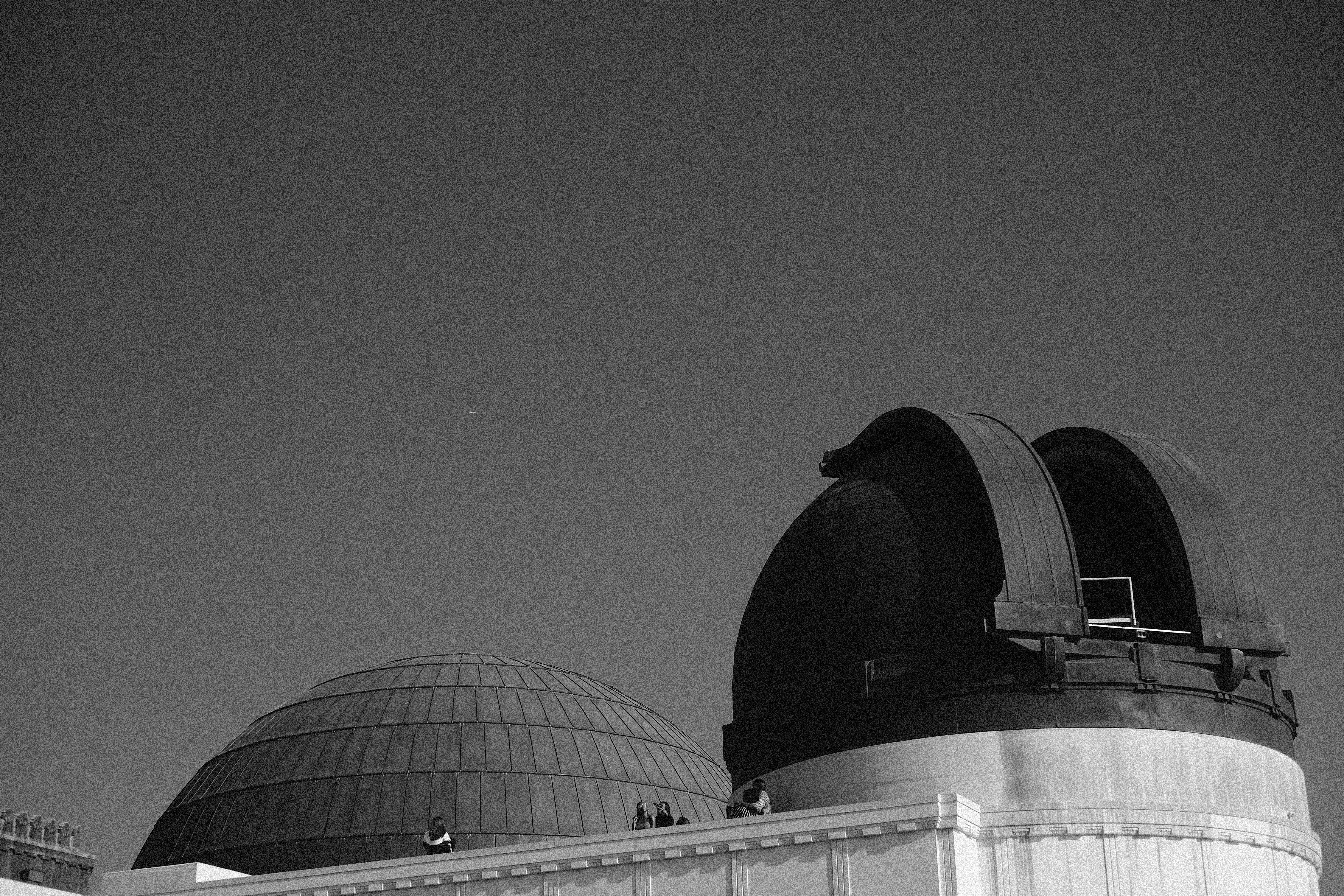 Two distinctive domes of an observatory under a clear sky, highlighting the interplay of architecture and astronomy.