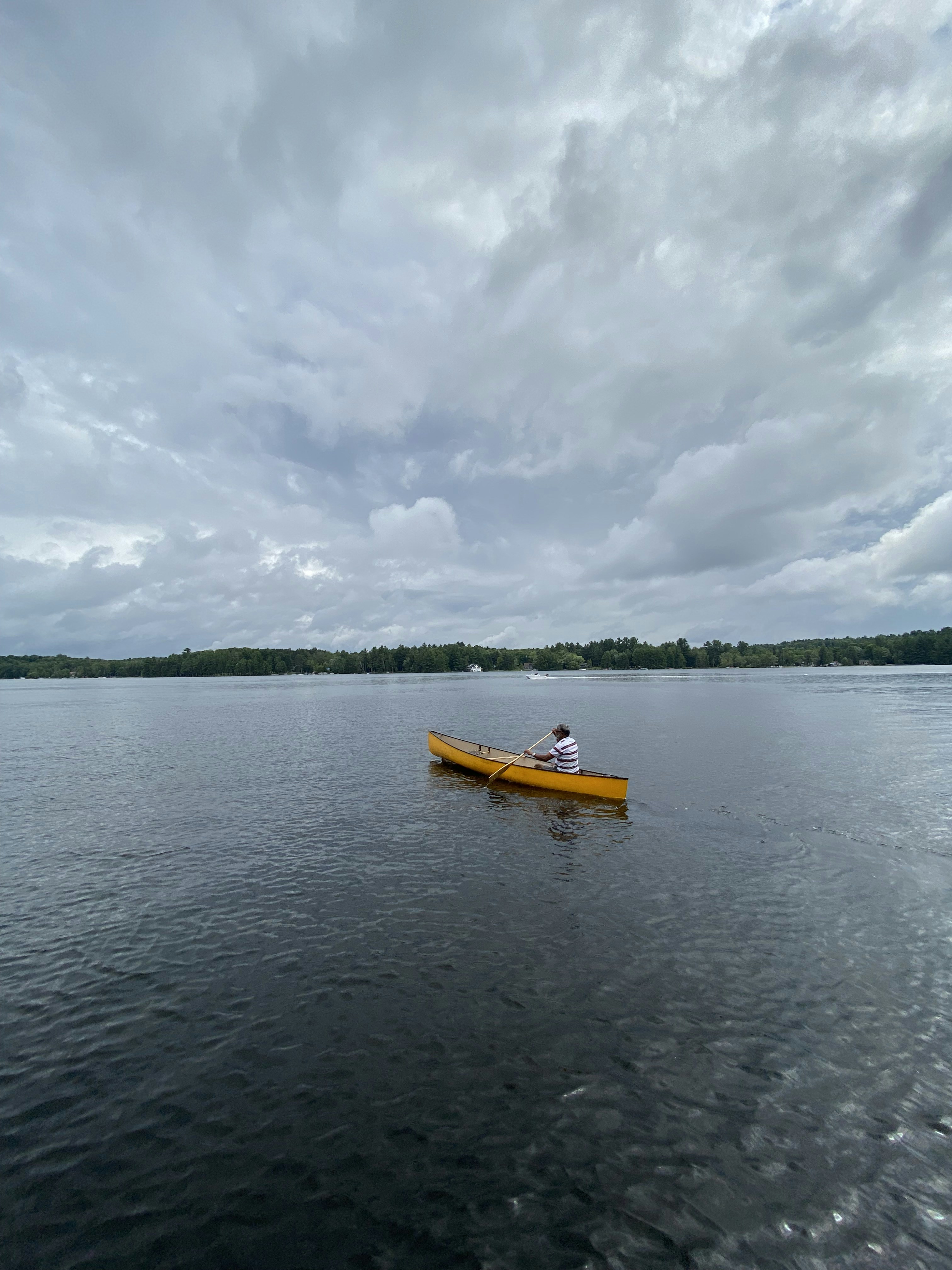 Yellow Canoe on a Quiet Lake Under an Overcast Sky