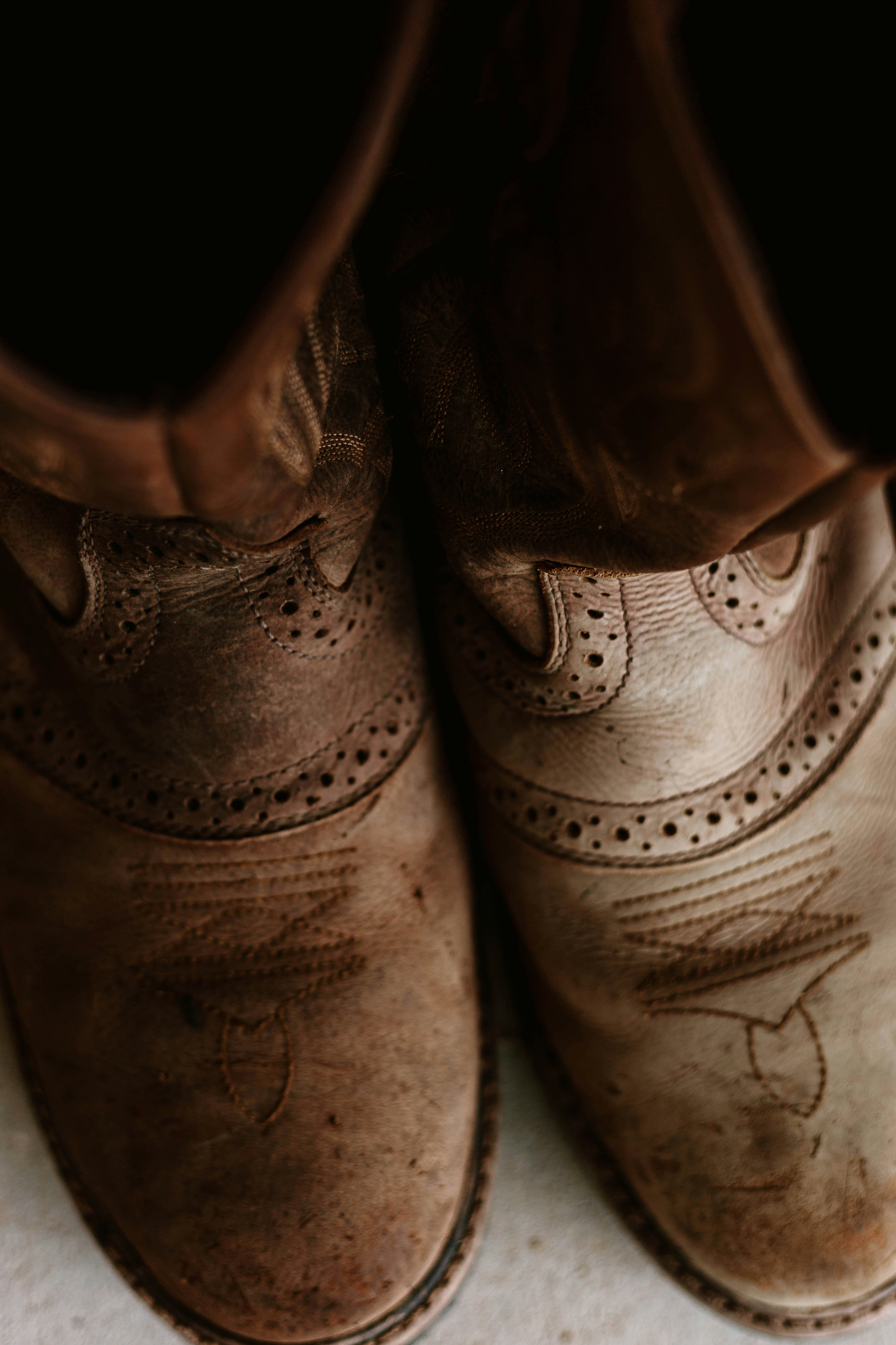 Between the Boots: Close-Up of Weathered Leather and Perforated Craft