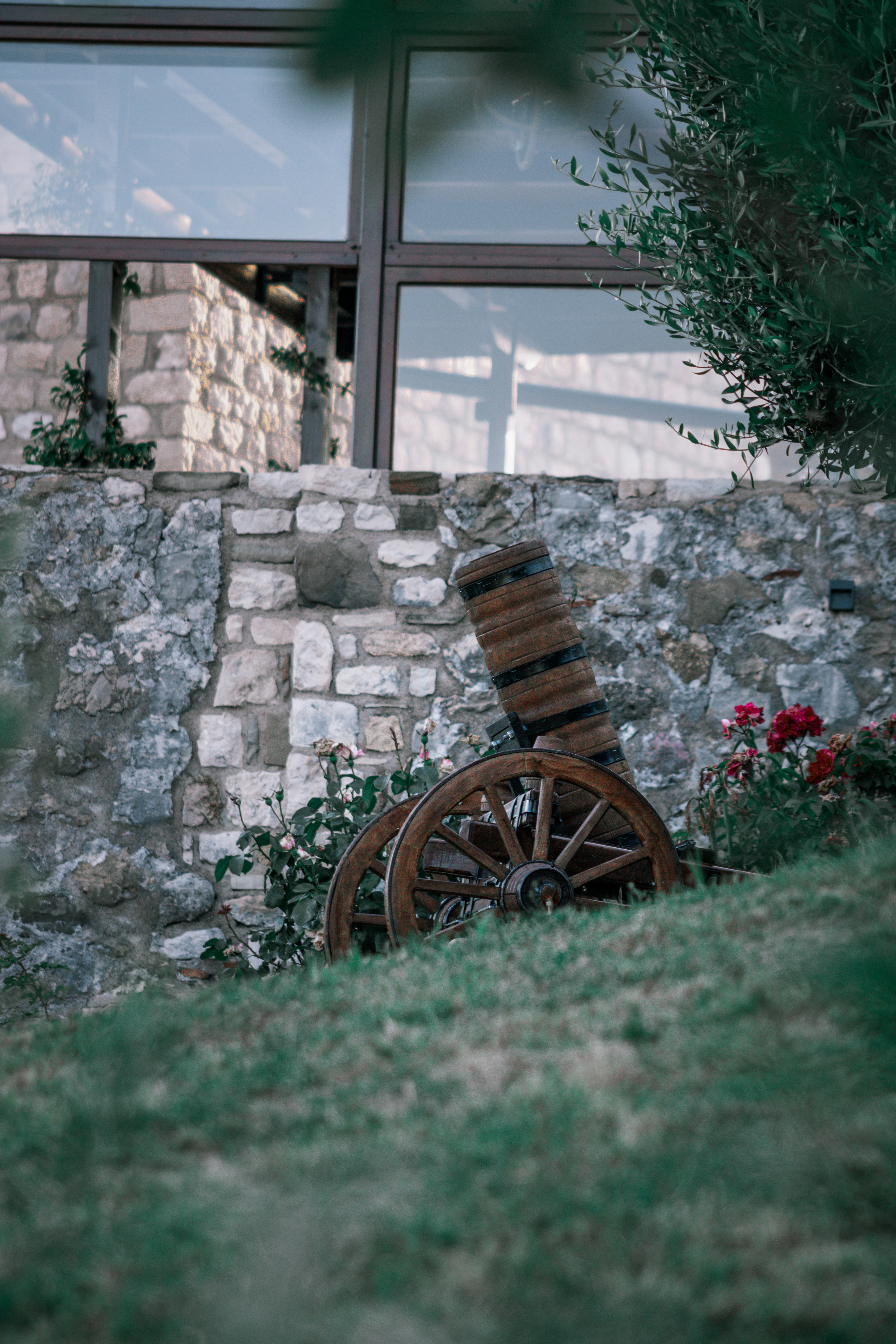 Rotated Wagon Wheel Against Stone Wall by a Garden Bloom