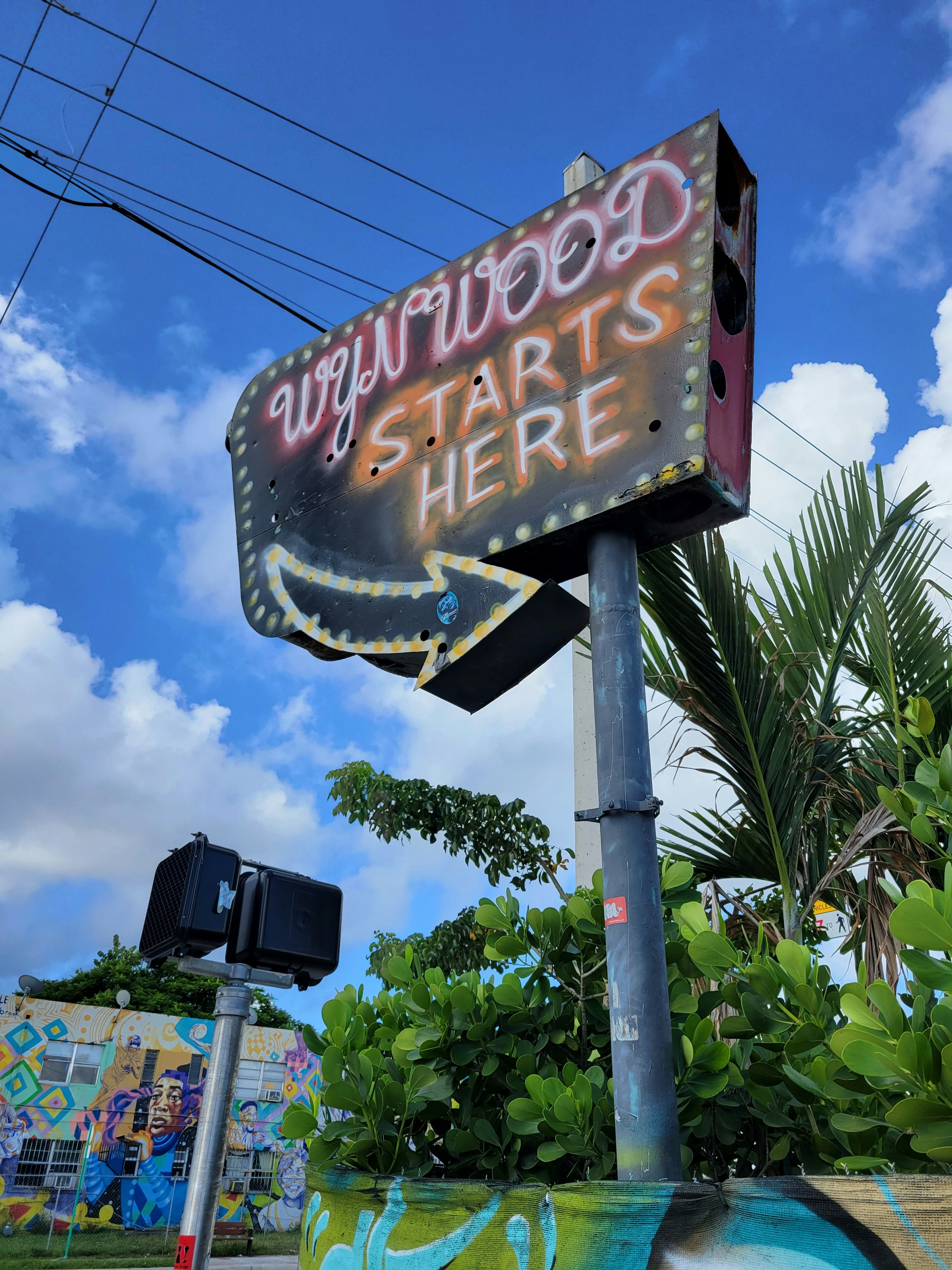 Neon Start Here: A Weathered Billboard Reaches for the Sky