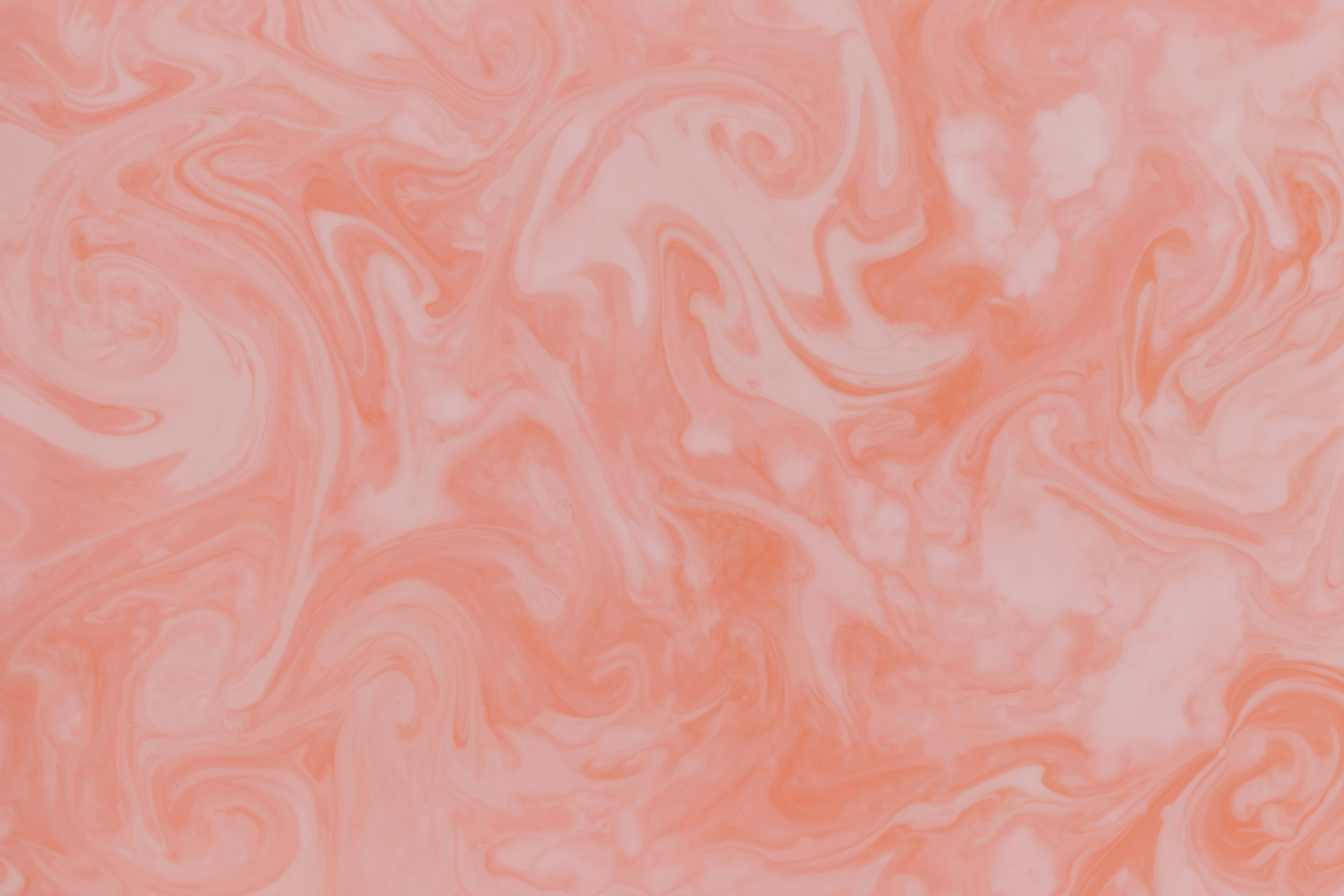 Abstract pattern of soft coral and white swirls creating a fluid, marble-like texture.