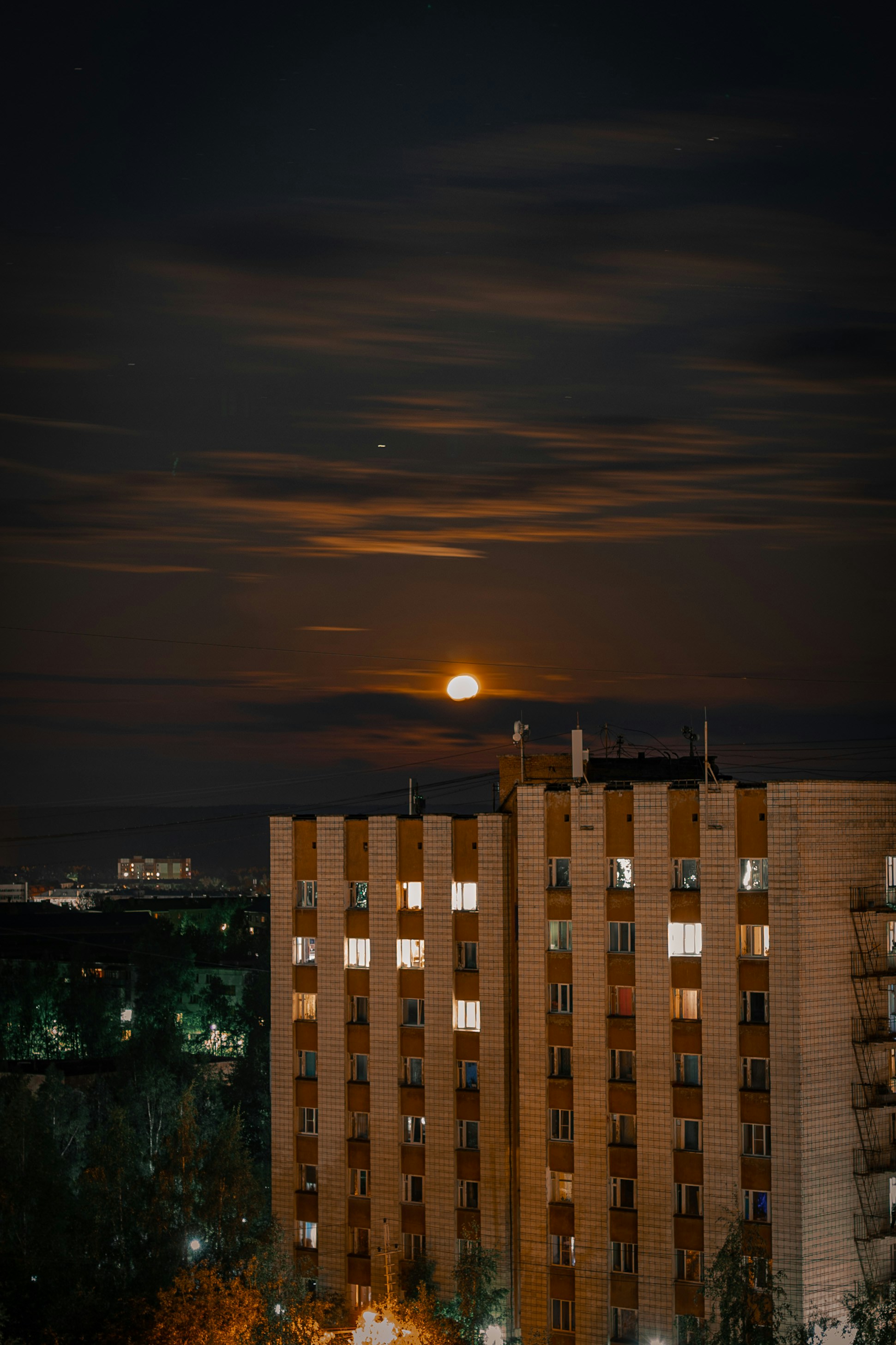 Moonlit Window Towers Over a Quiet Urban Night