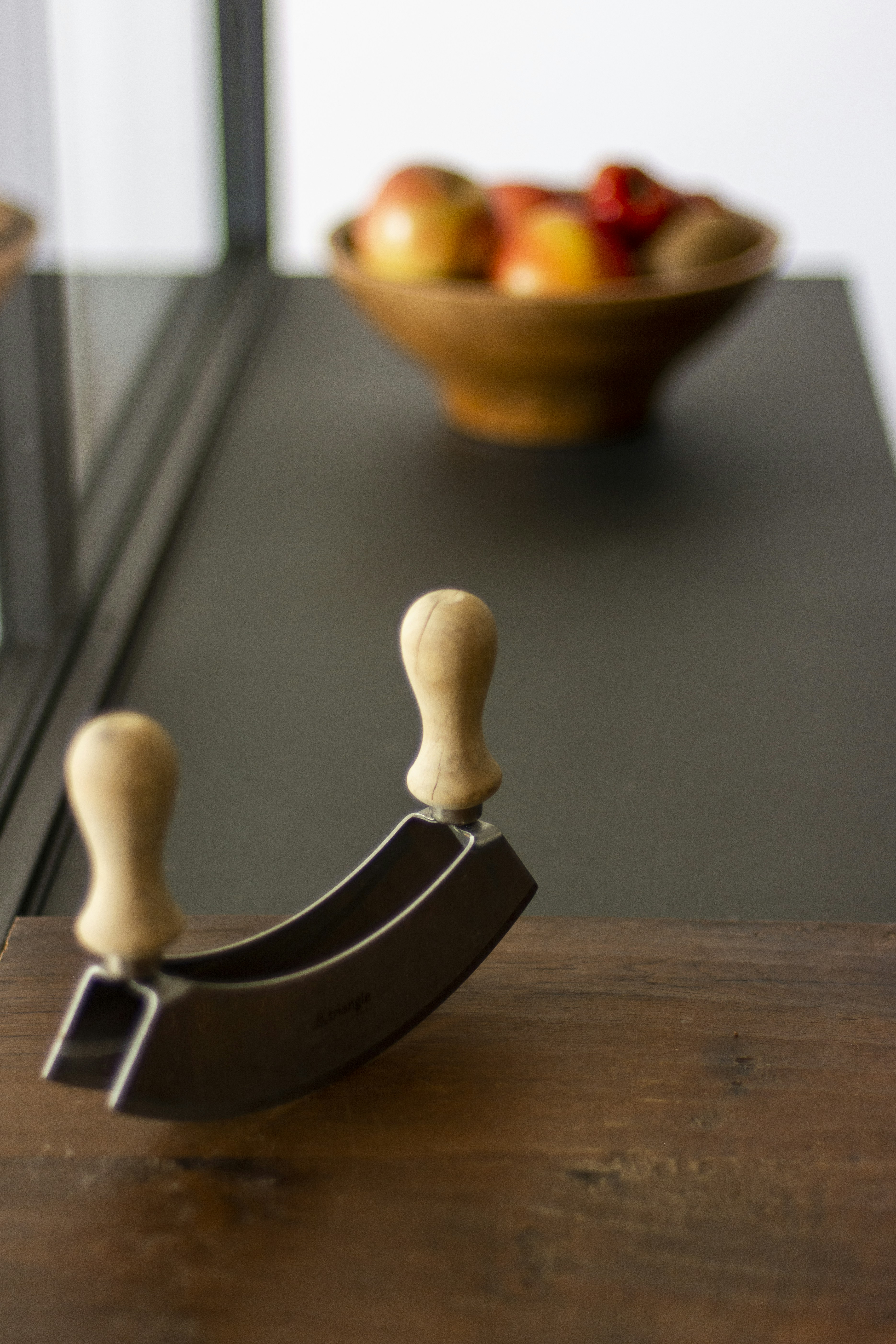 Mezzaluna on cutting board | white wooden bone on brown wooden table
