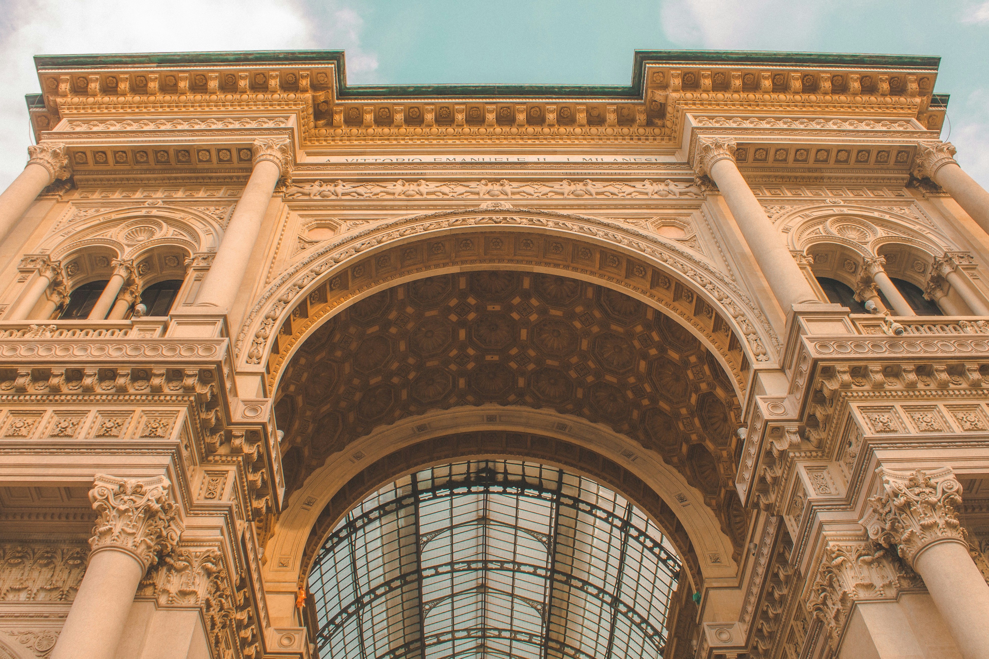 Under the Grand Arch: Ornate Facade Framed by a Glass Vault
