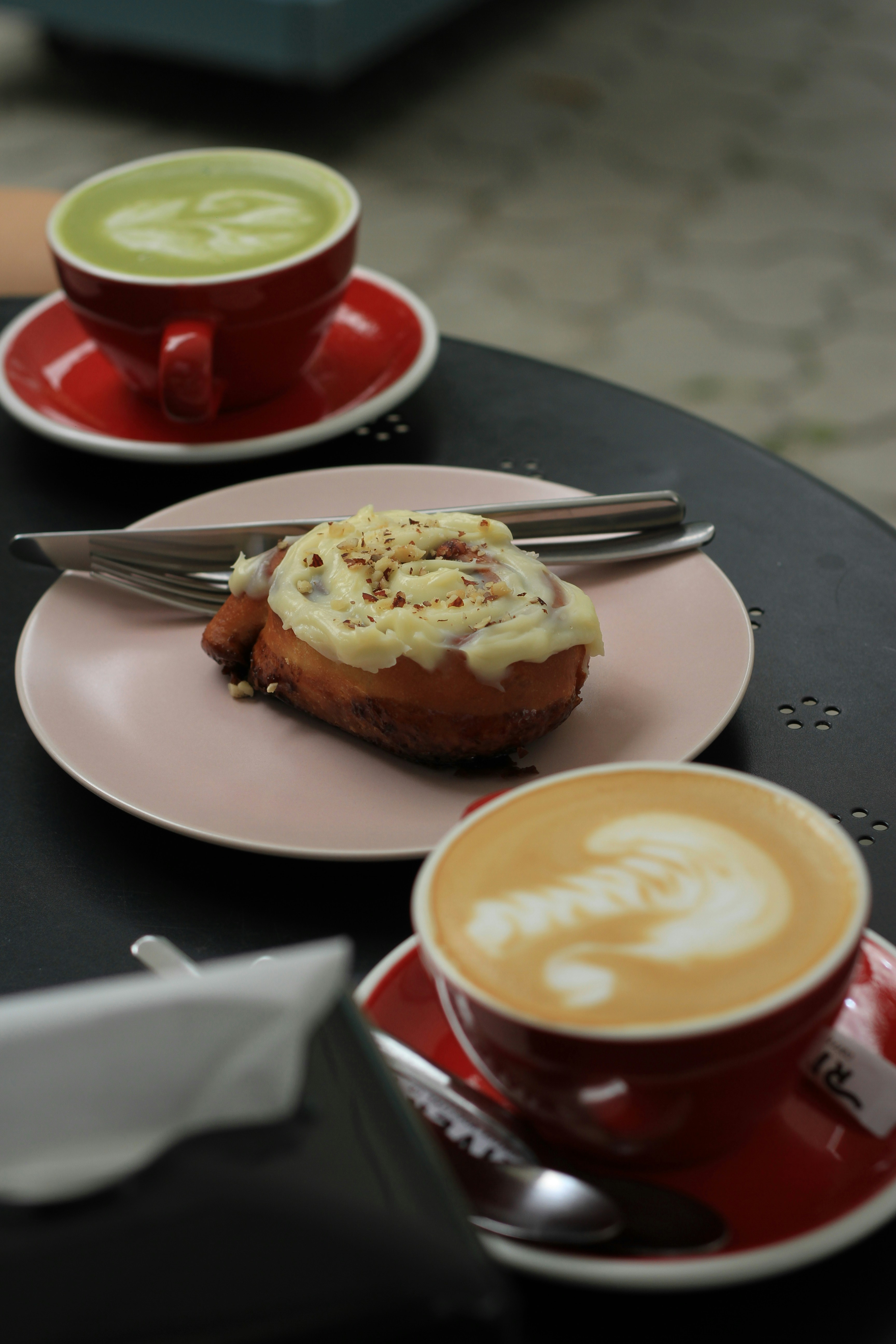Cream-topped Pastry on a Blush Plate, Framed by Café Lattes