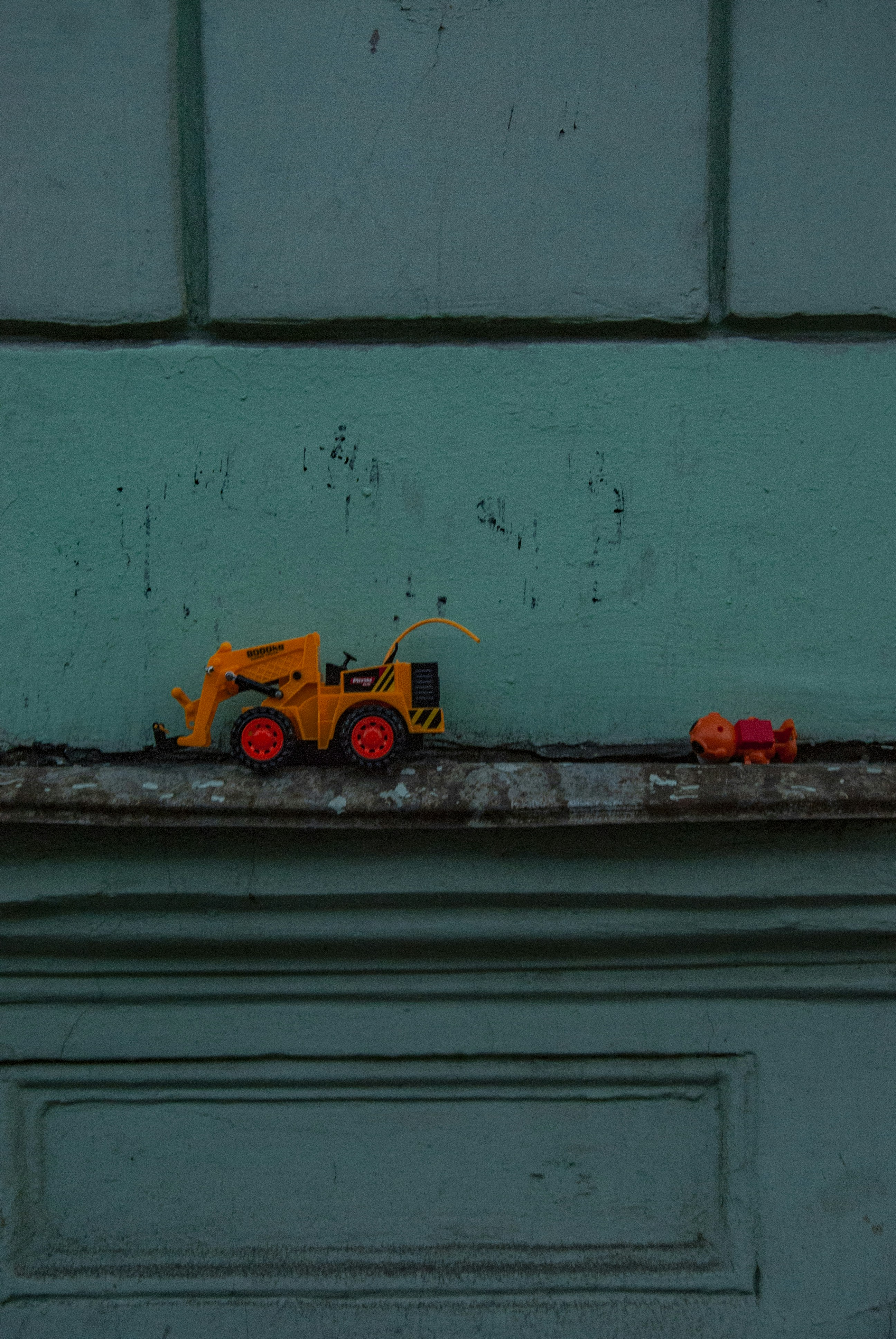 Tiny Excavator on a Teal Wall: A Quiet Playground Scene