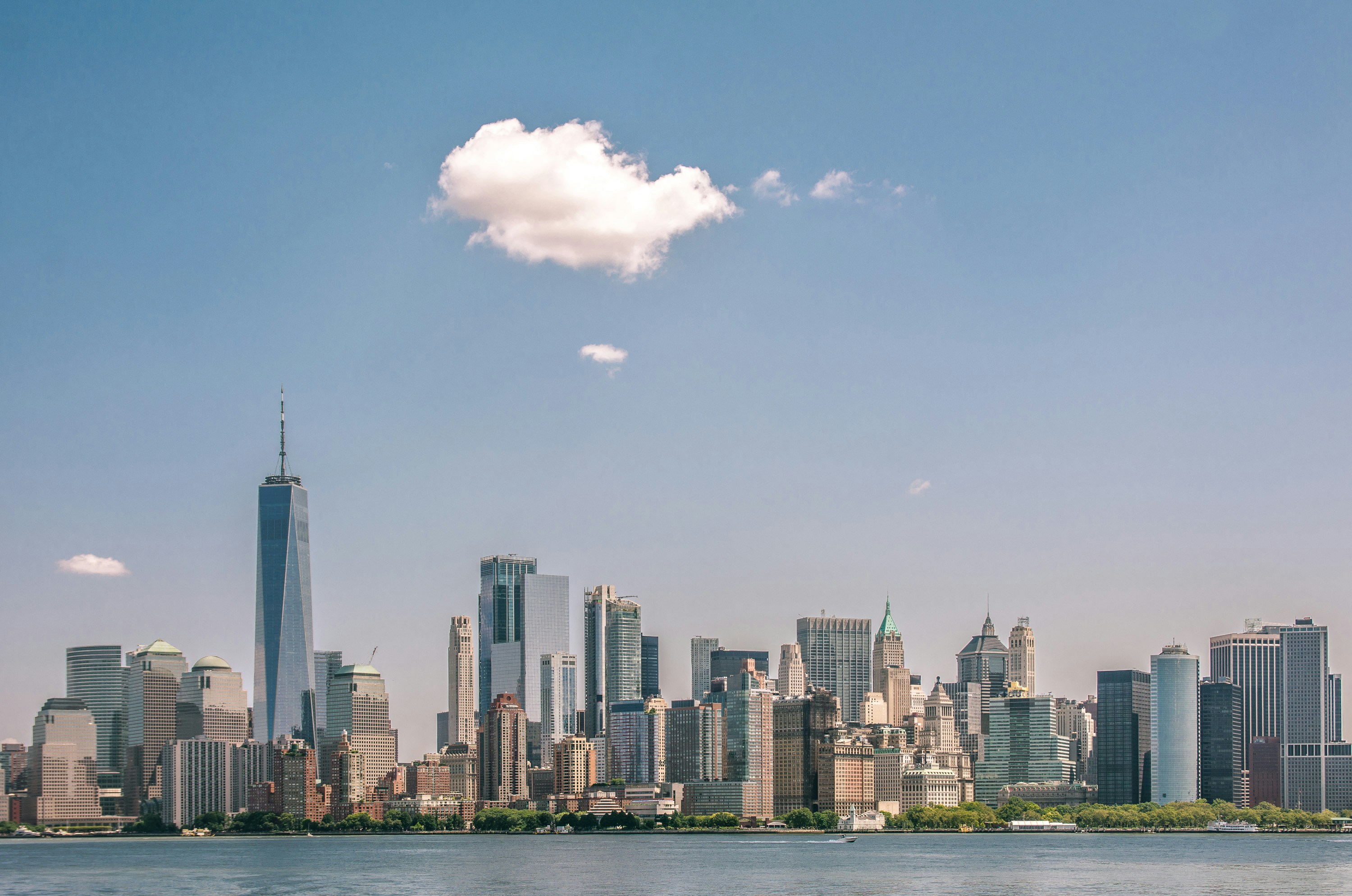 City skyline featuring towering skyscrapers and a solitary cloud above, reflecting modern architecture and urban life.