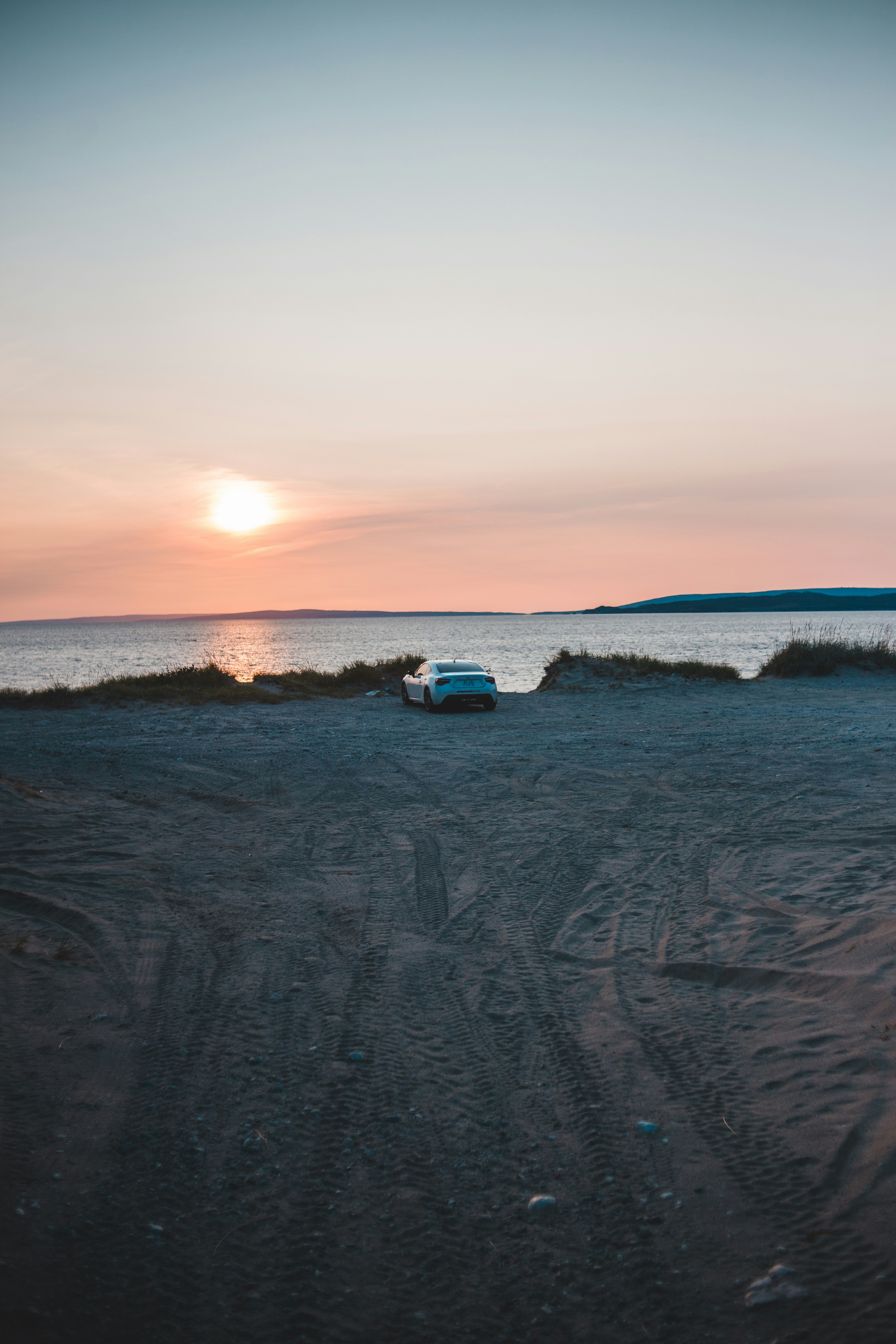 Sunset Isolation: A Pebbled Path to the Car by the Sea